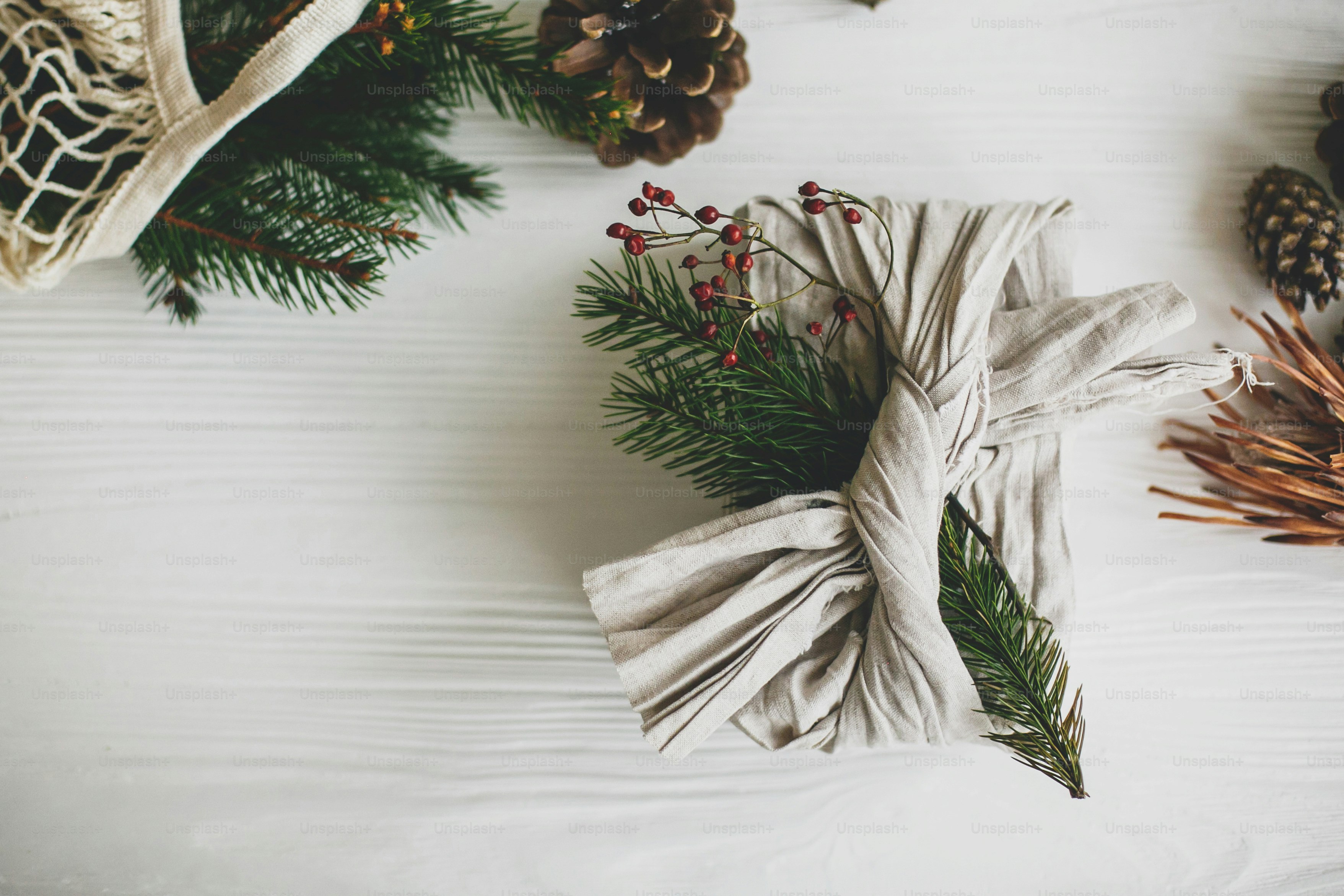 Stylish christmas gift flat lay. Present wrapped in linen fabric ...
