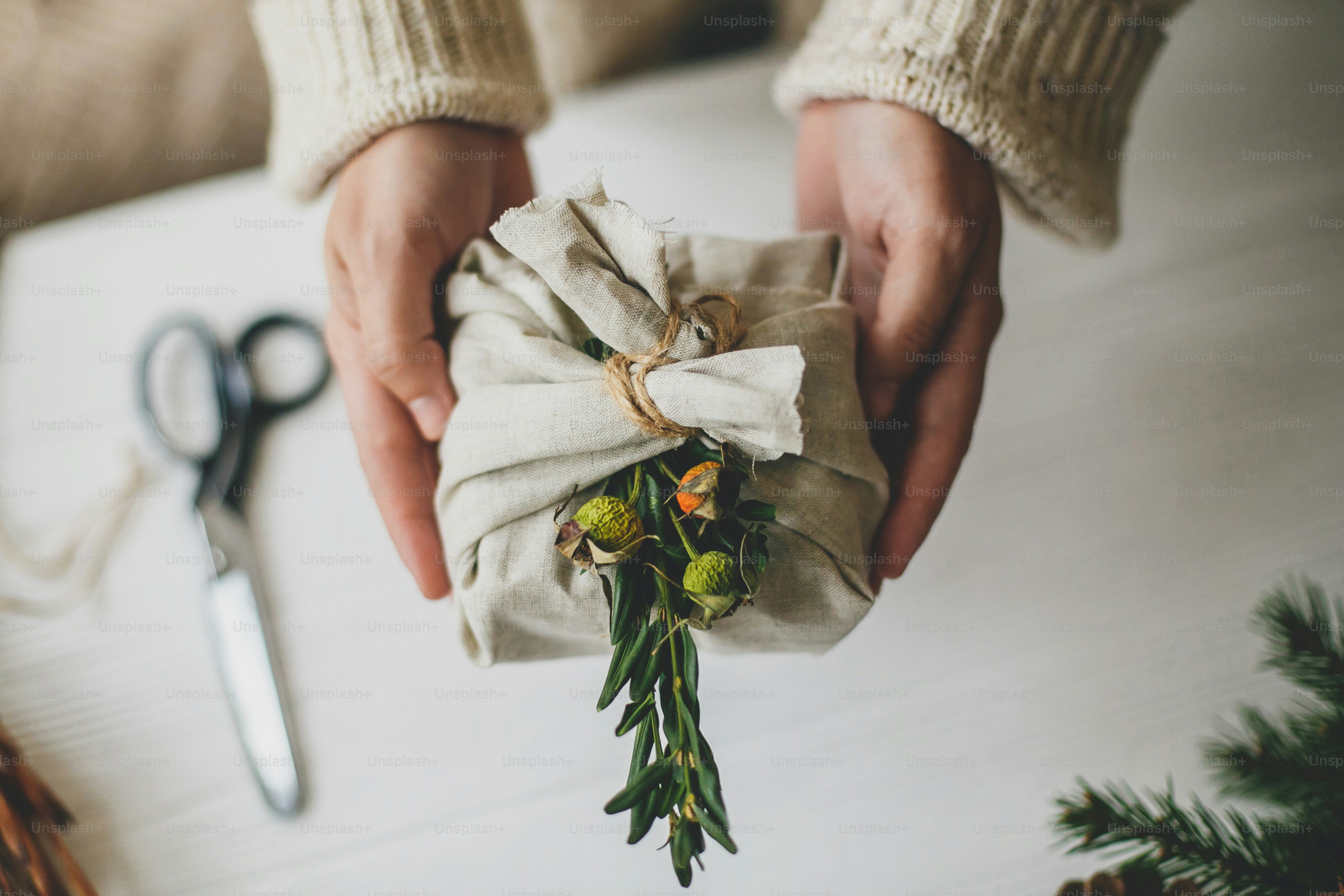 Zero waste Christmas gift. Hands holding stylish present wrapped in ...