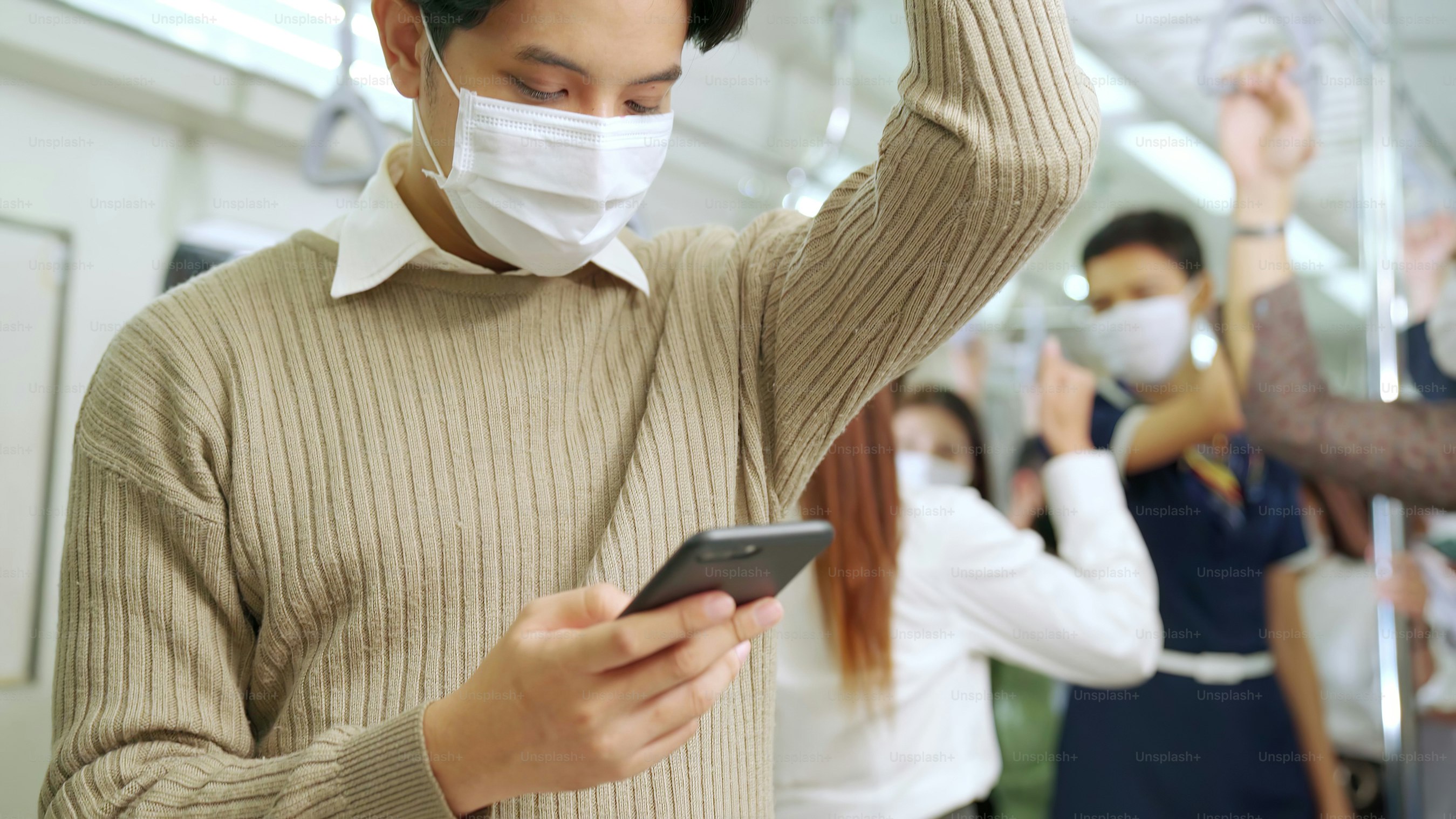 Traveler wearing face mask while using mobile phone on public train ...