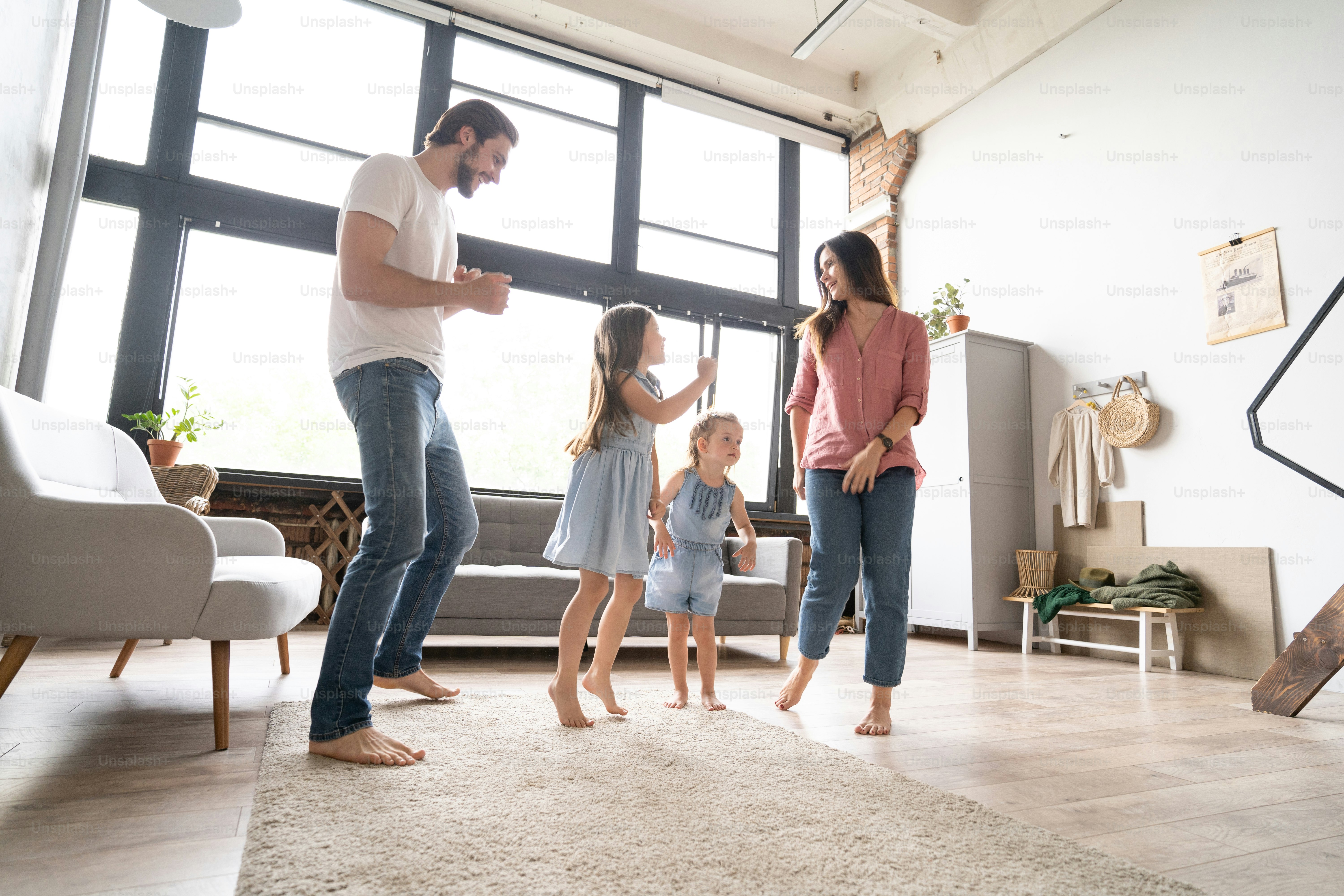 Famille heureuse mère père et enfant fille dansant à la maison photo ...
