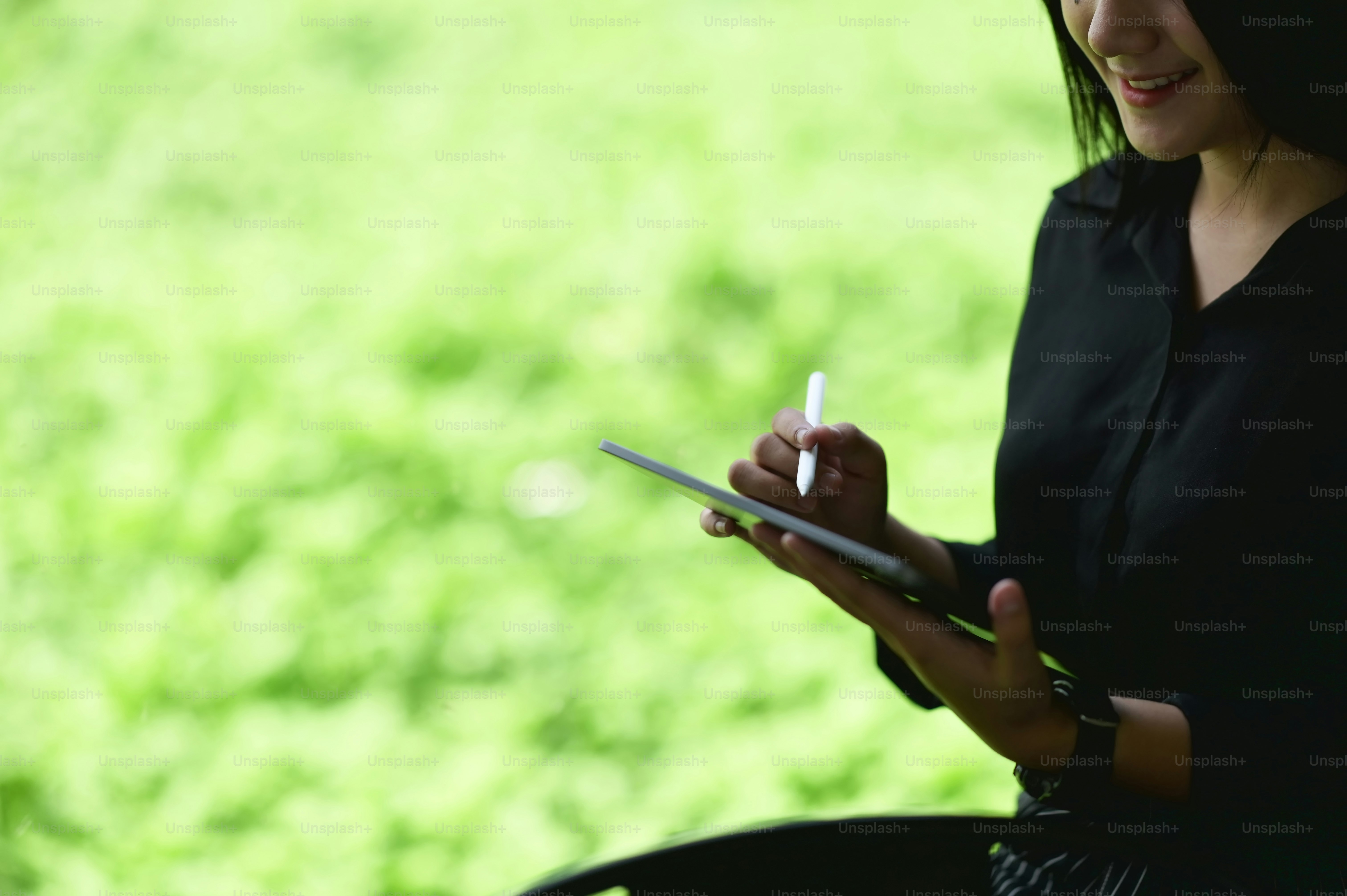 Copy space of woman using digital tablet with stylus pen at garden ...