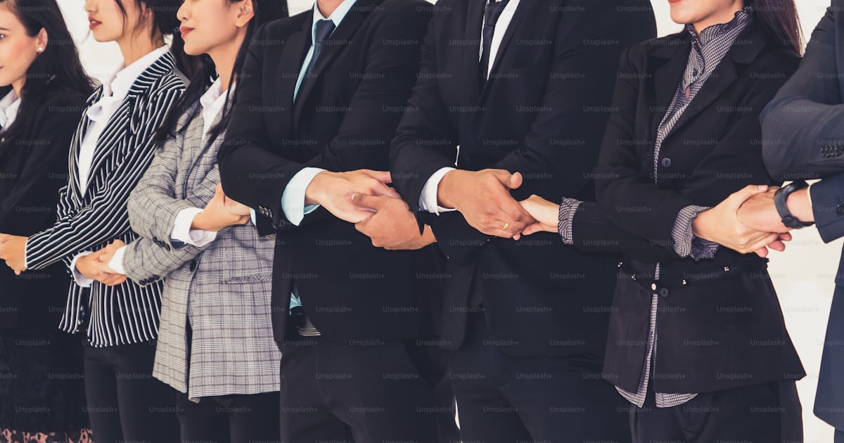성공적인 사업가들은 함께 서서 노동자 공동체의 강한 관계를 보여줍니다 현대 사무실에서 강력한 그룹 팀워크를 표현하는 사업가와