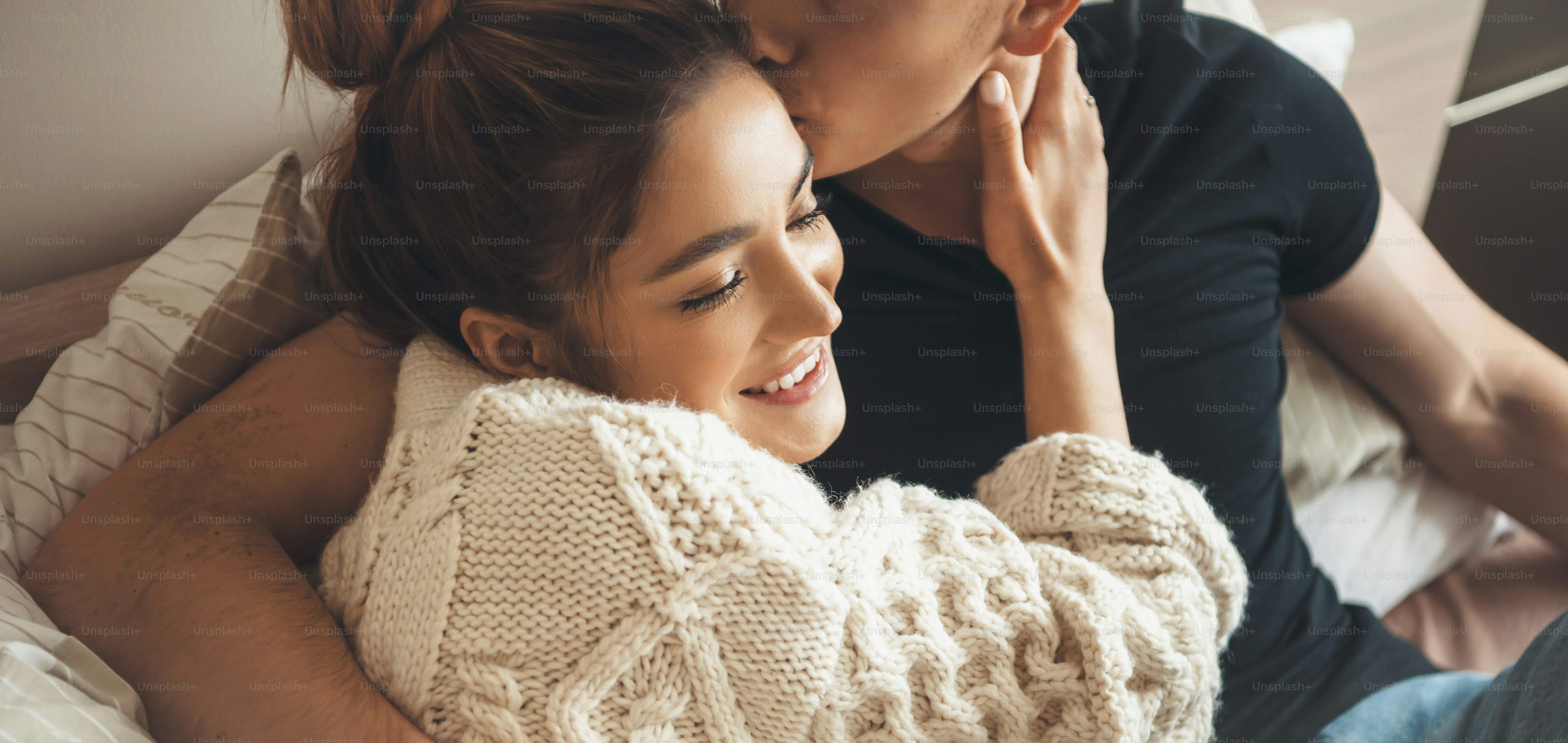 Foto Encantadora pareja acostada en la cama y abrazada mientras se ...