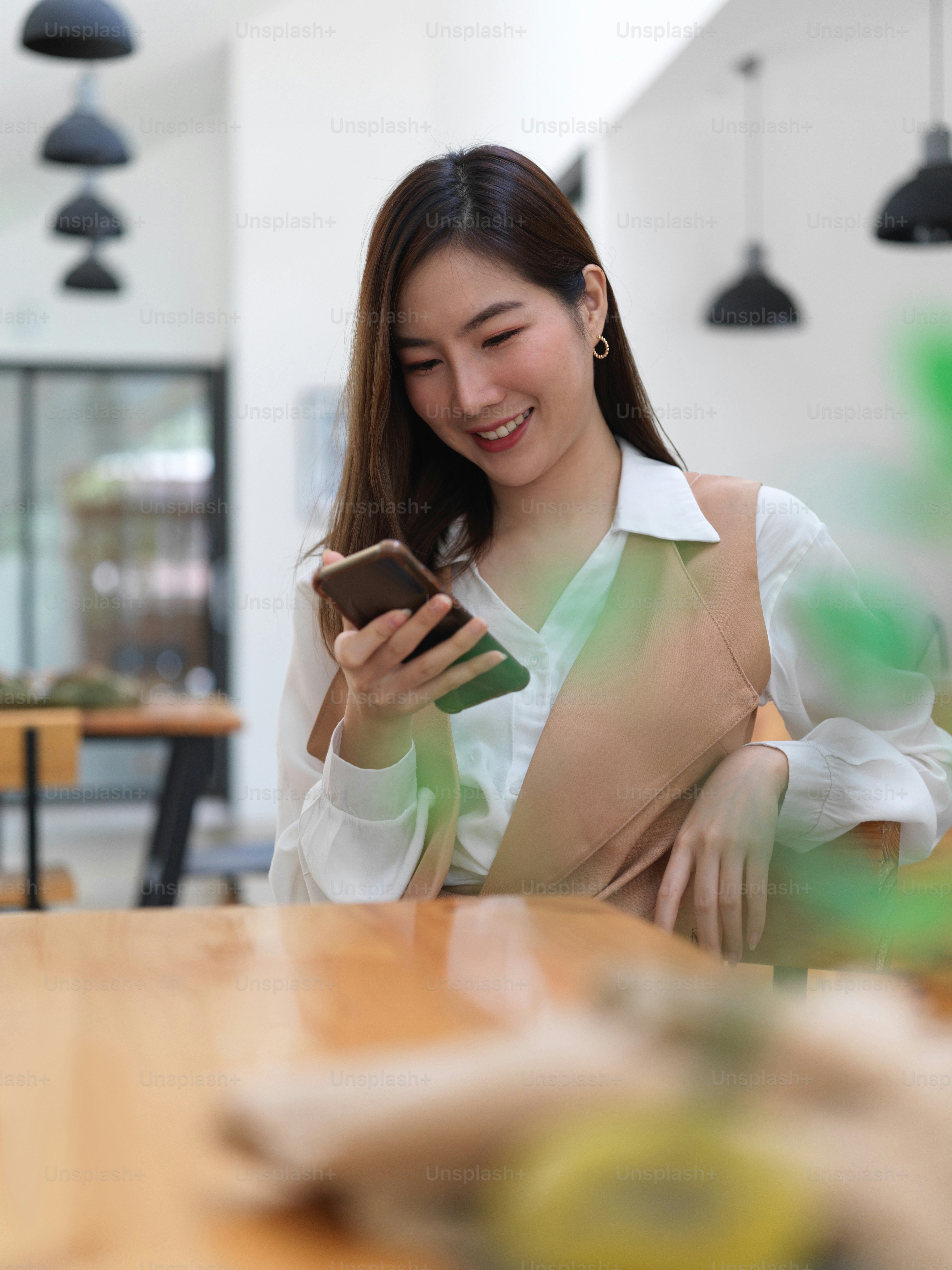Portrait of female teenager smiling while texting on smartphone in ...