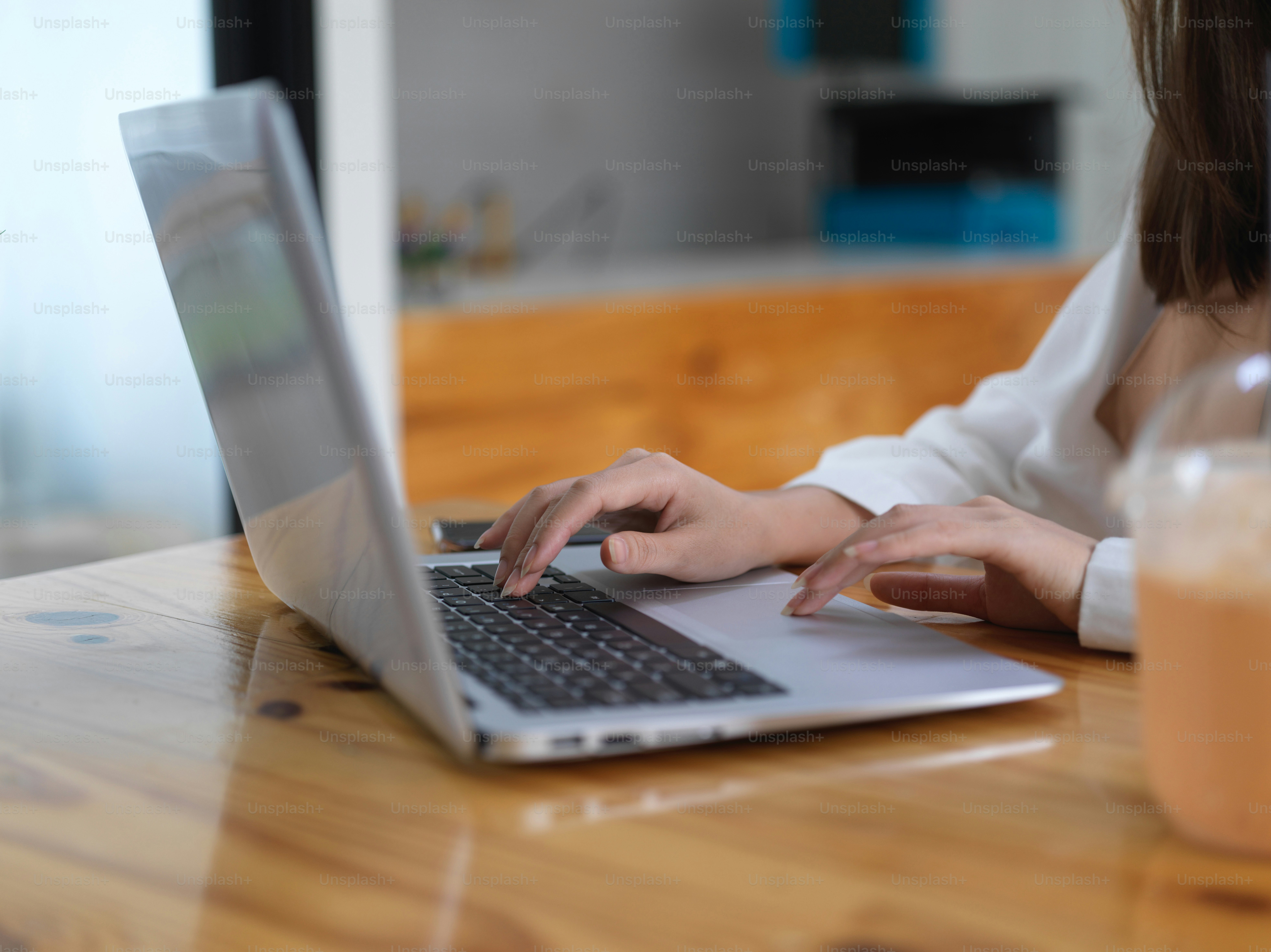 Side view of female student typing on laptop keyboard while doing ...