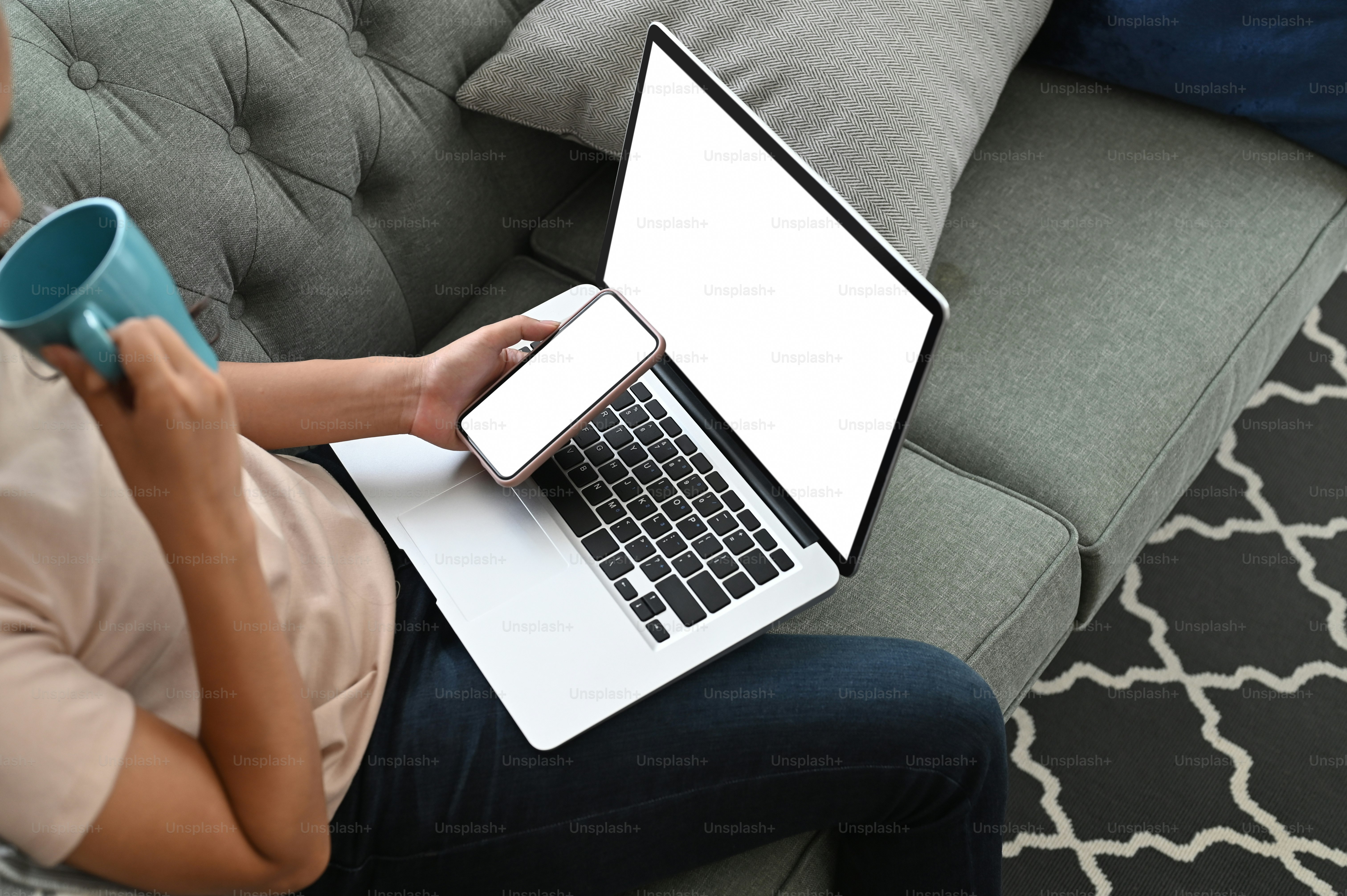 Young female tech user relaxing on sofa holding laptop computer and ...