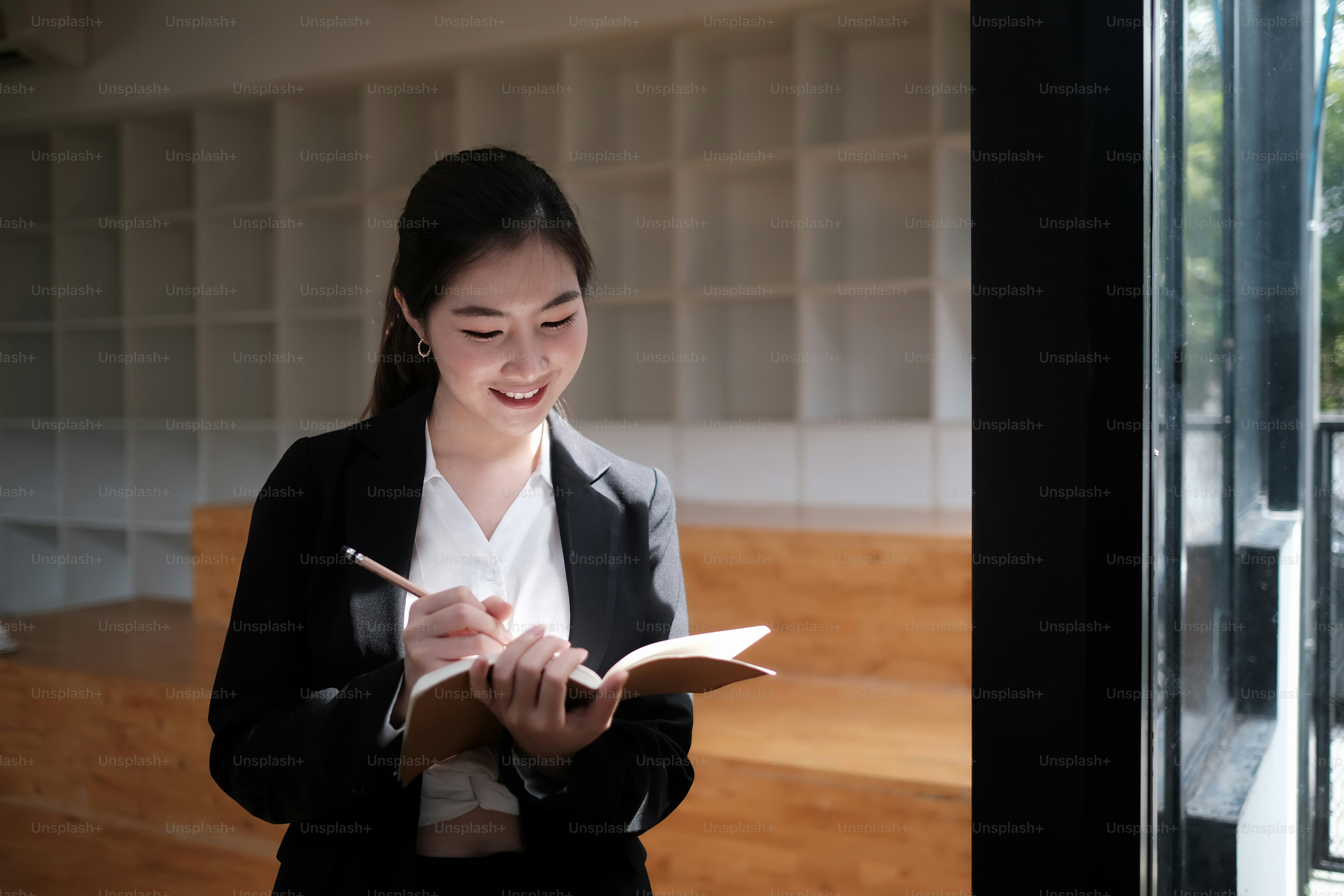 Pretty woman writing on notebook paper at business office. photo ...
