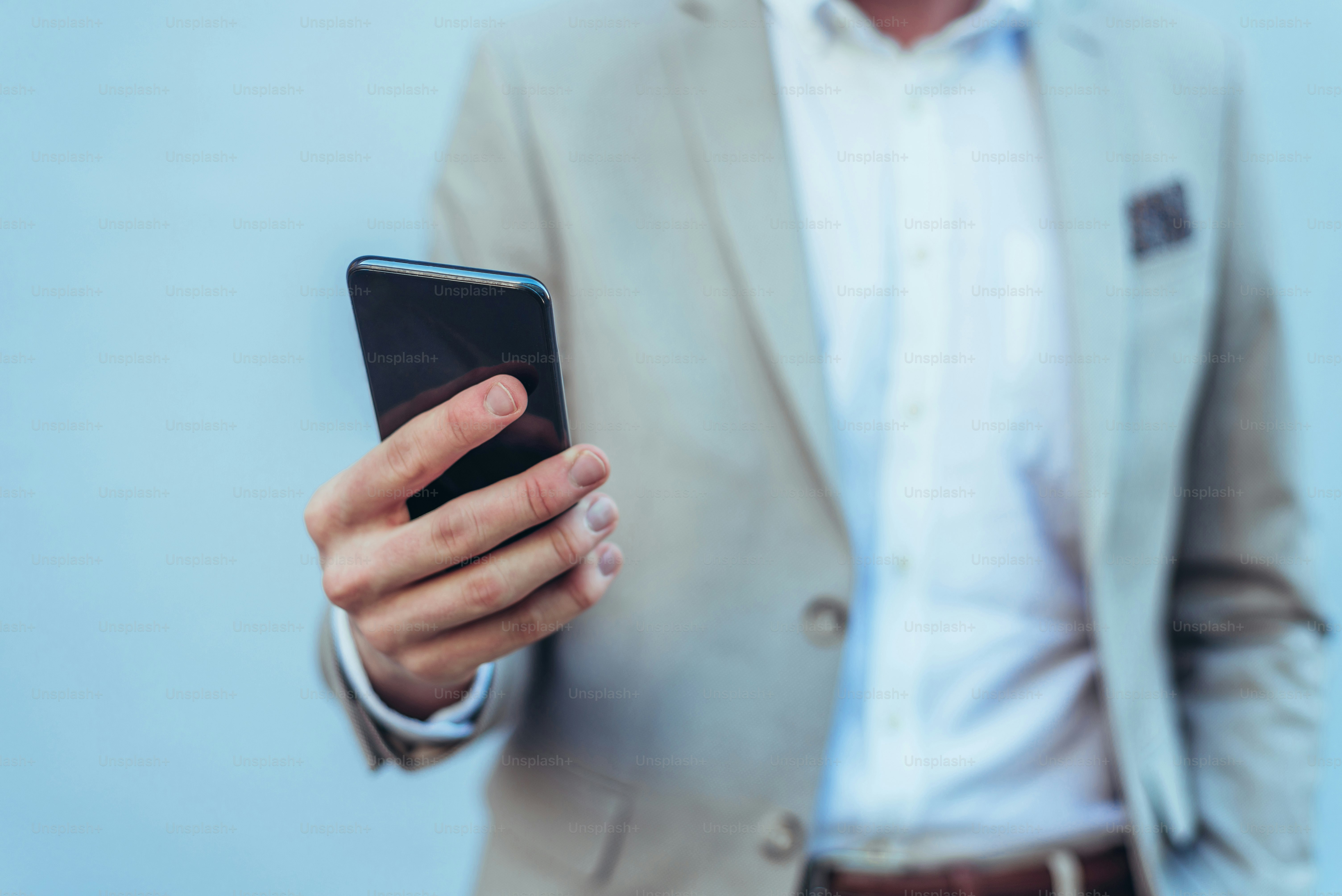 Cropped shot of a young businessman using his smartphone to send some ...