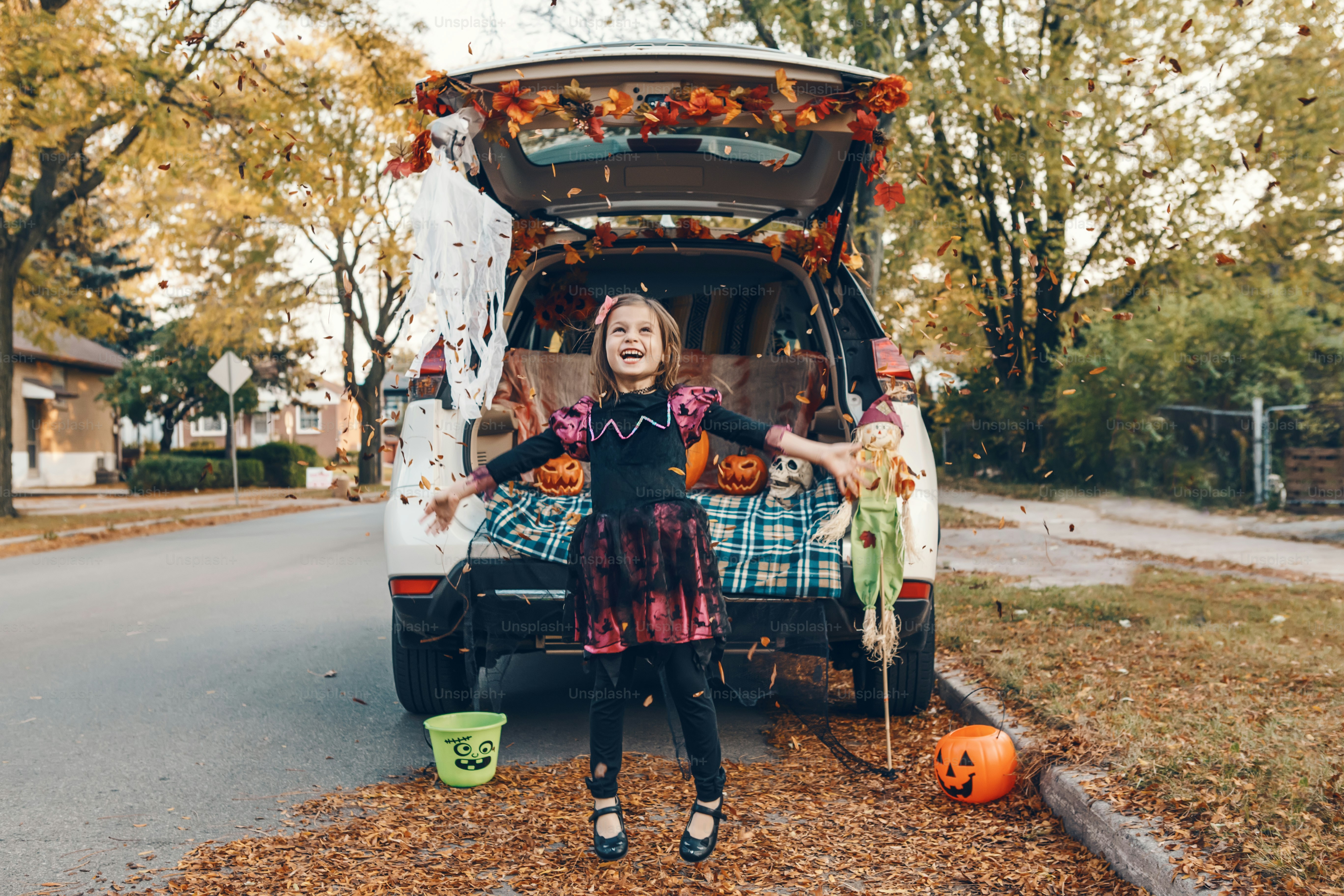 Trick or trunk. Children siblings sisters celebrating Halloween in ...