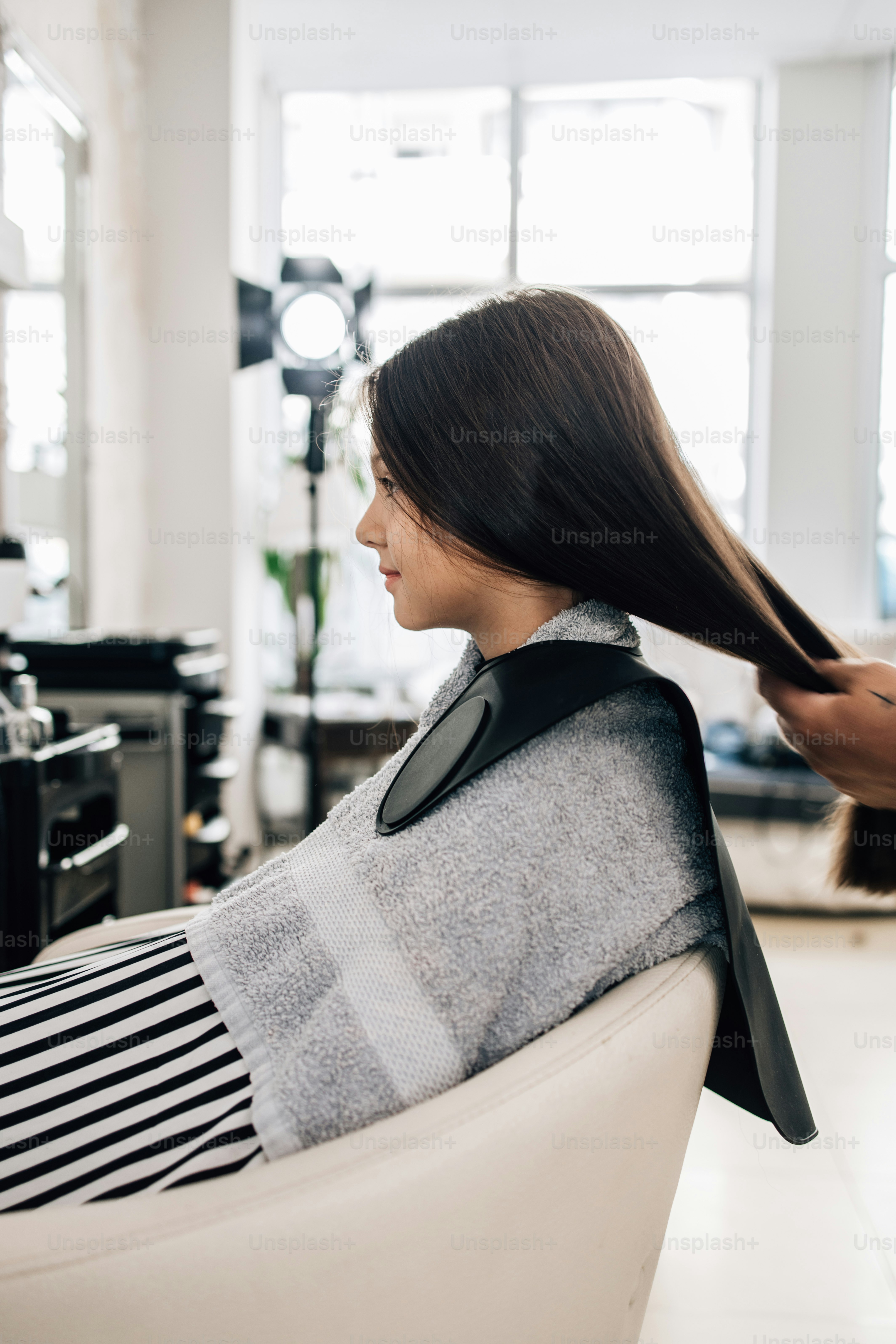 Young girl model preparing for fashion show. Professional hairdresser ...
