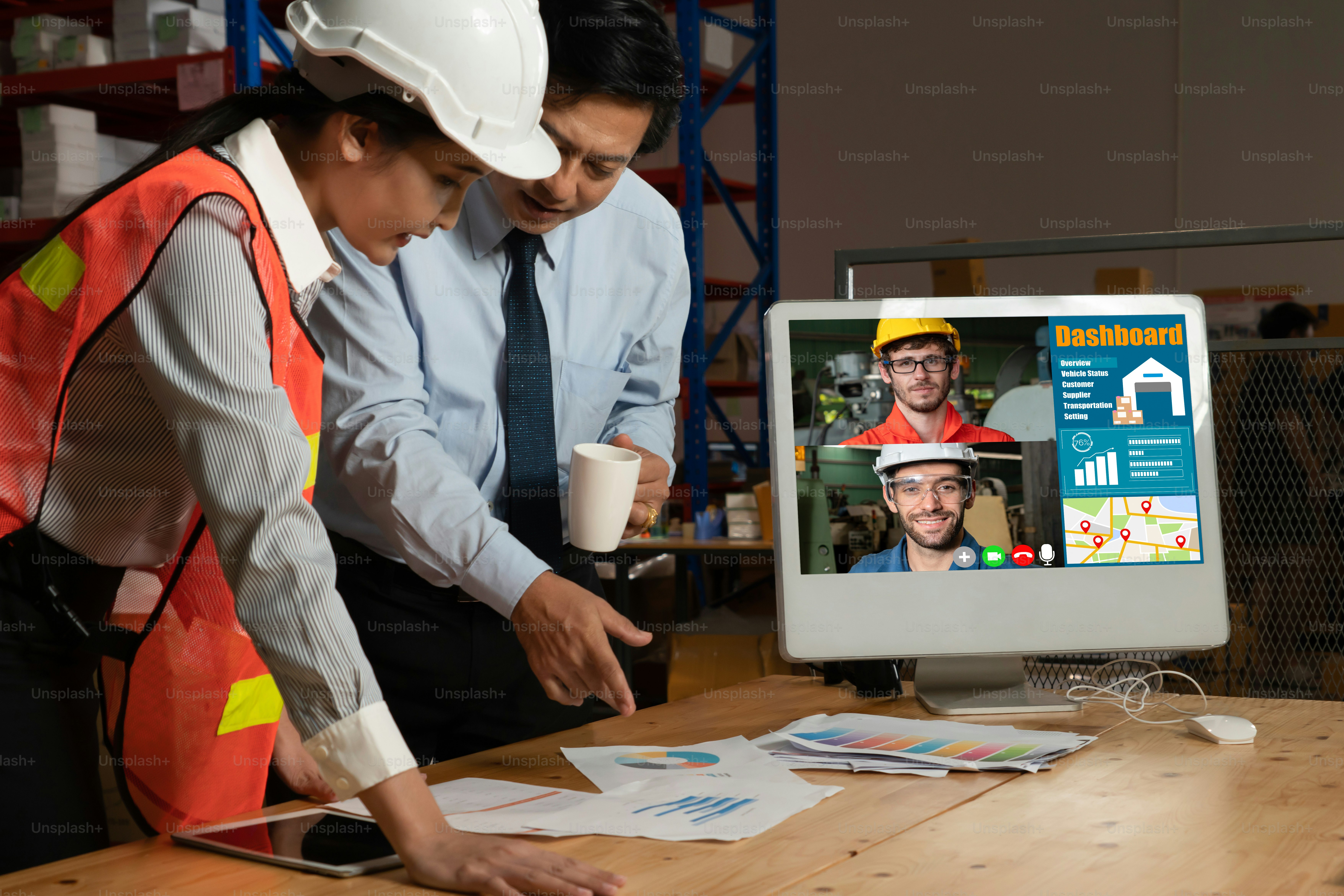 Warehouse staff talking on video call at computer screen in storage ...