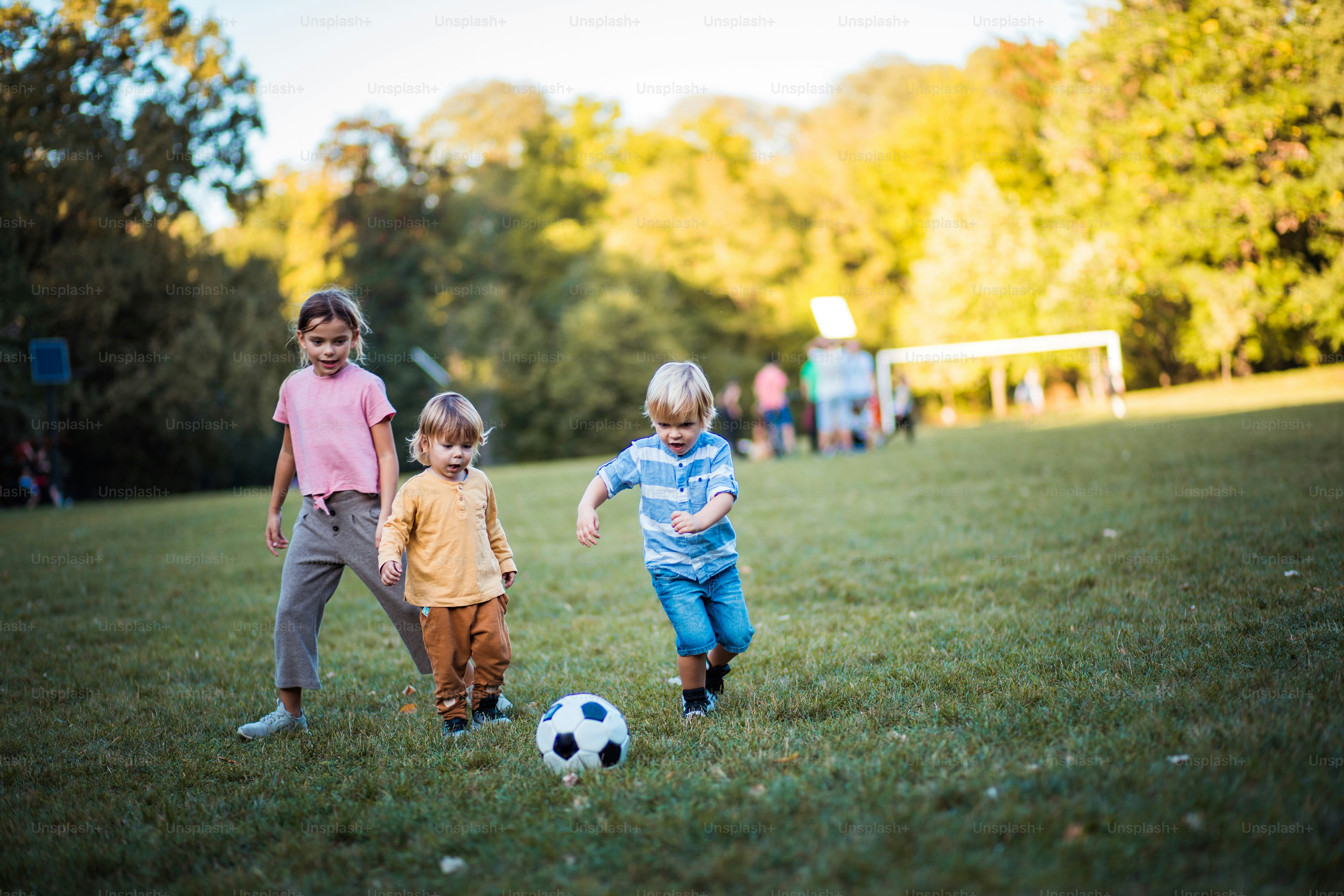 Sister playing football with brothers. photo – Kids soccer Image on ...
