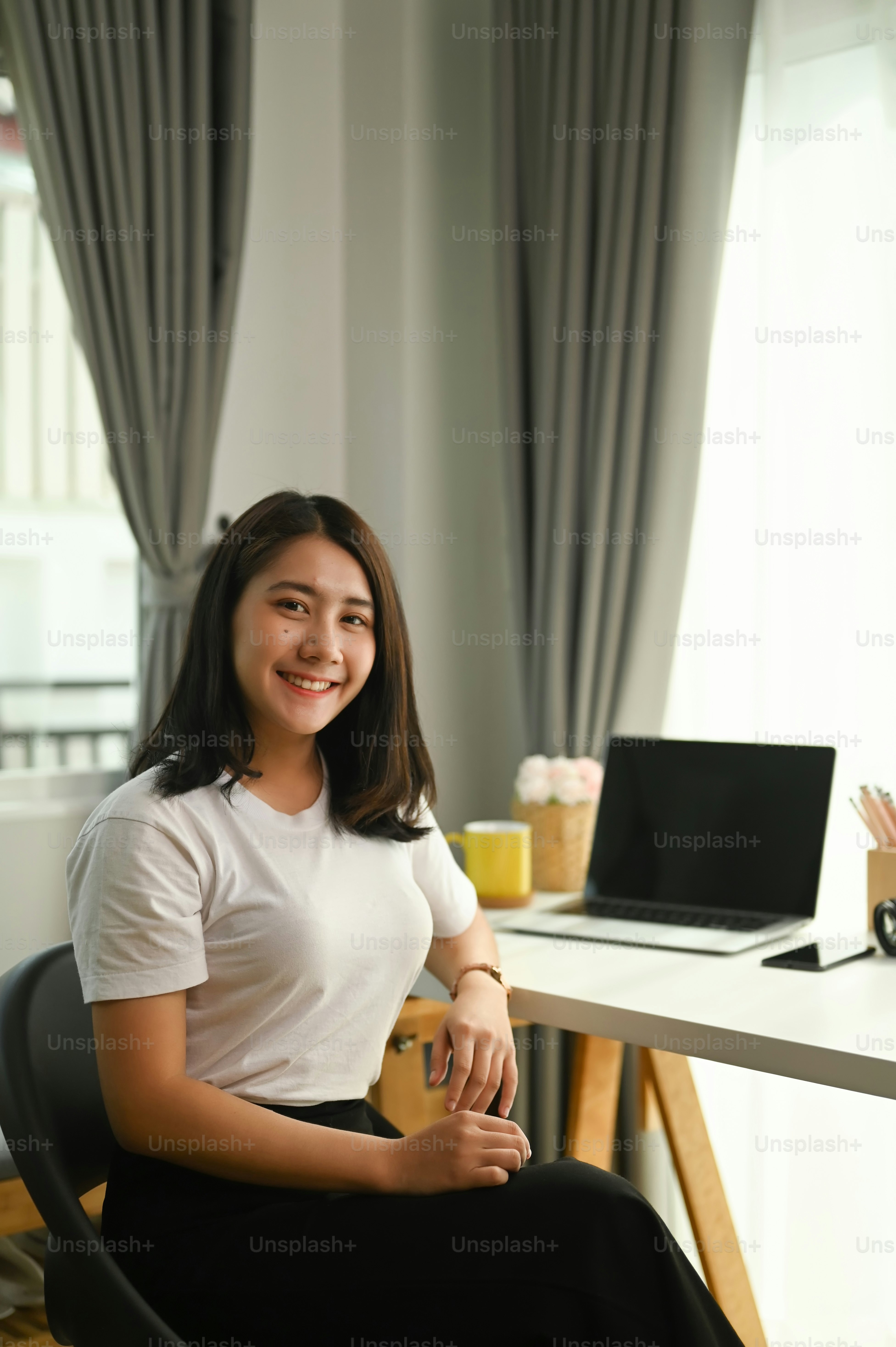 Portrait of female smile and looking into camera while sitting in home ...