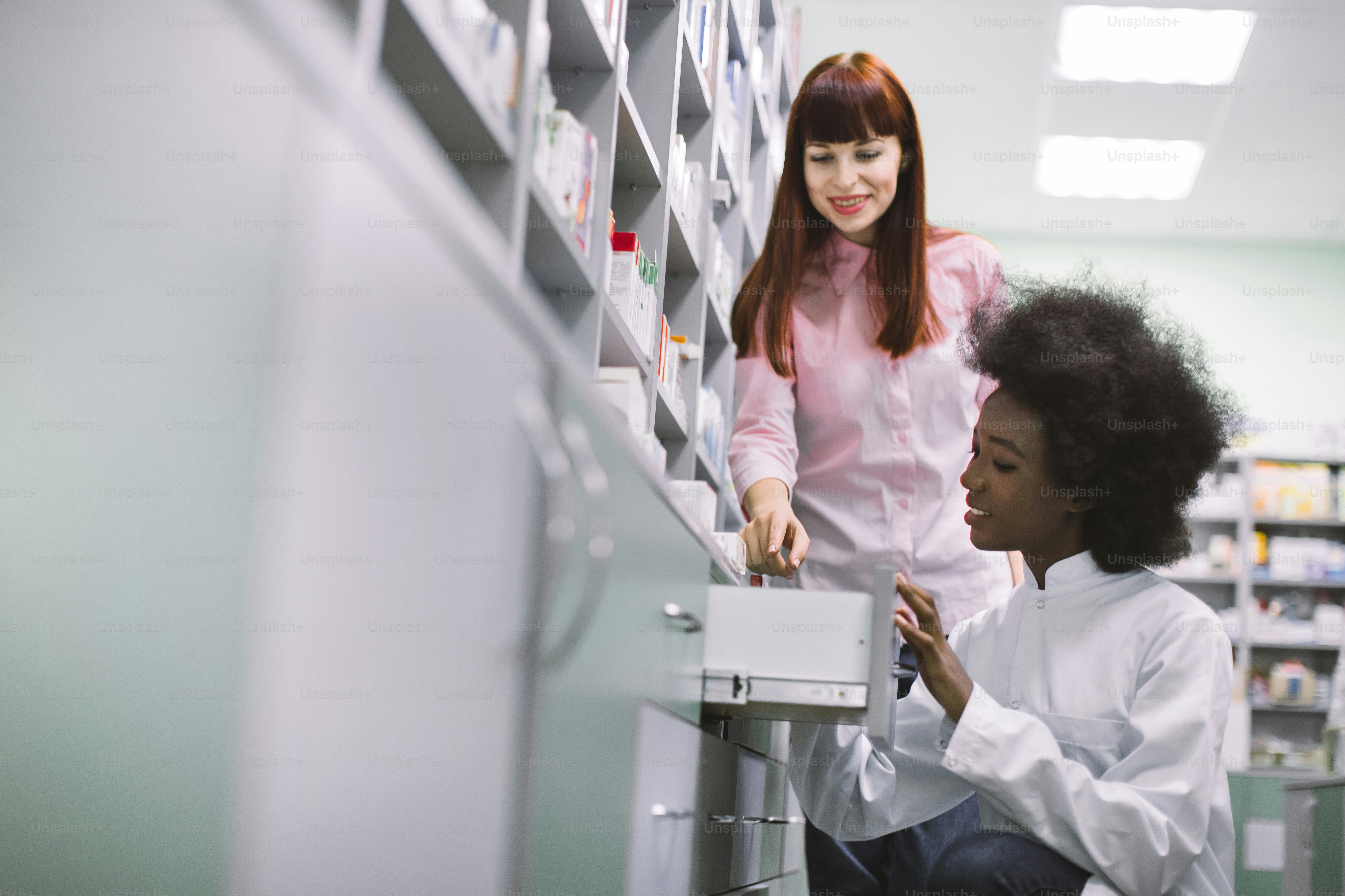 Young Caucasian red haired woman client is asking pretty young African ...