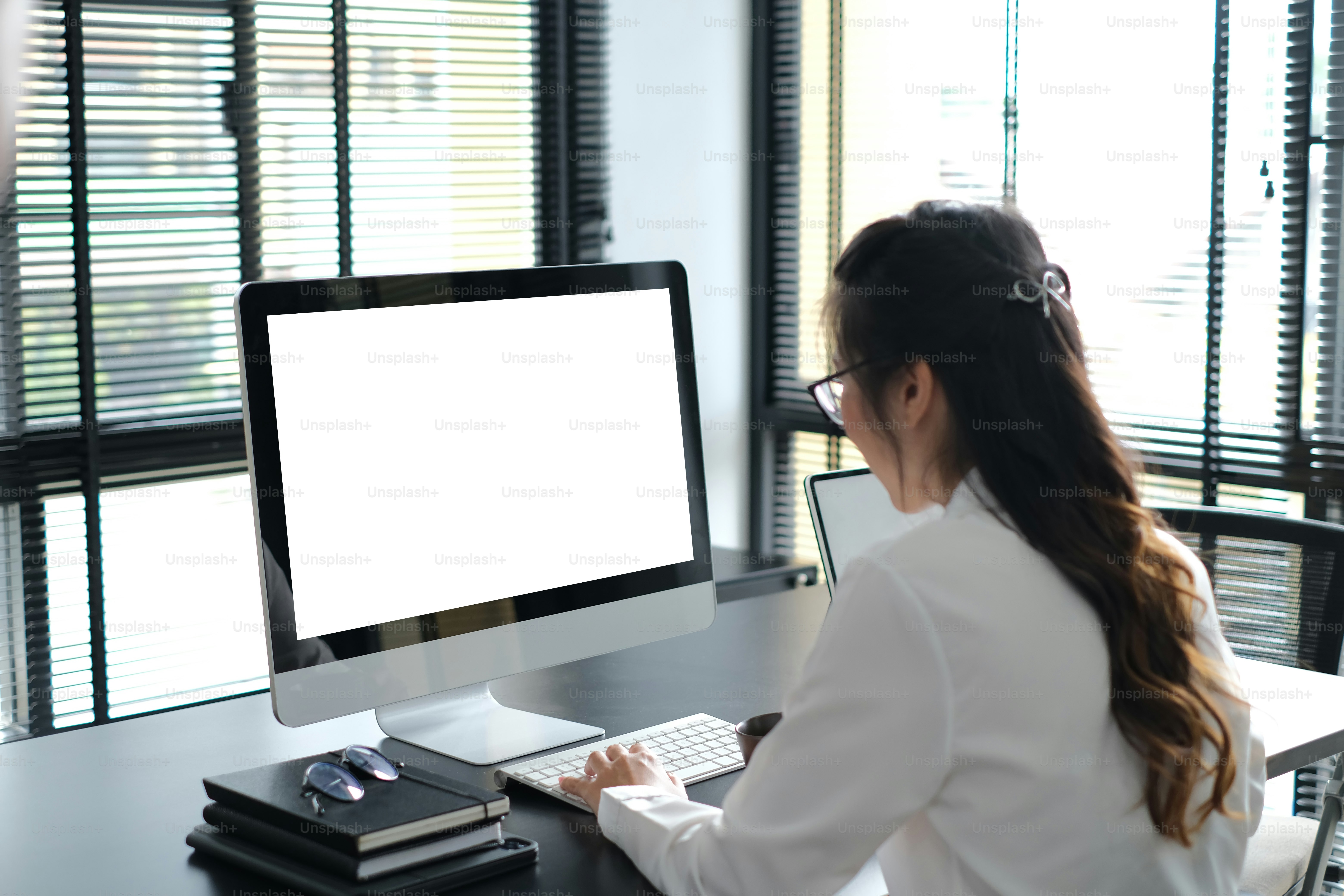 Rear view portrait of a businesswoman sitting on her workplace in the ...