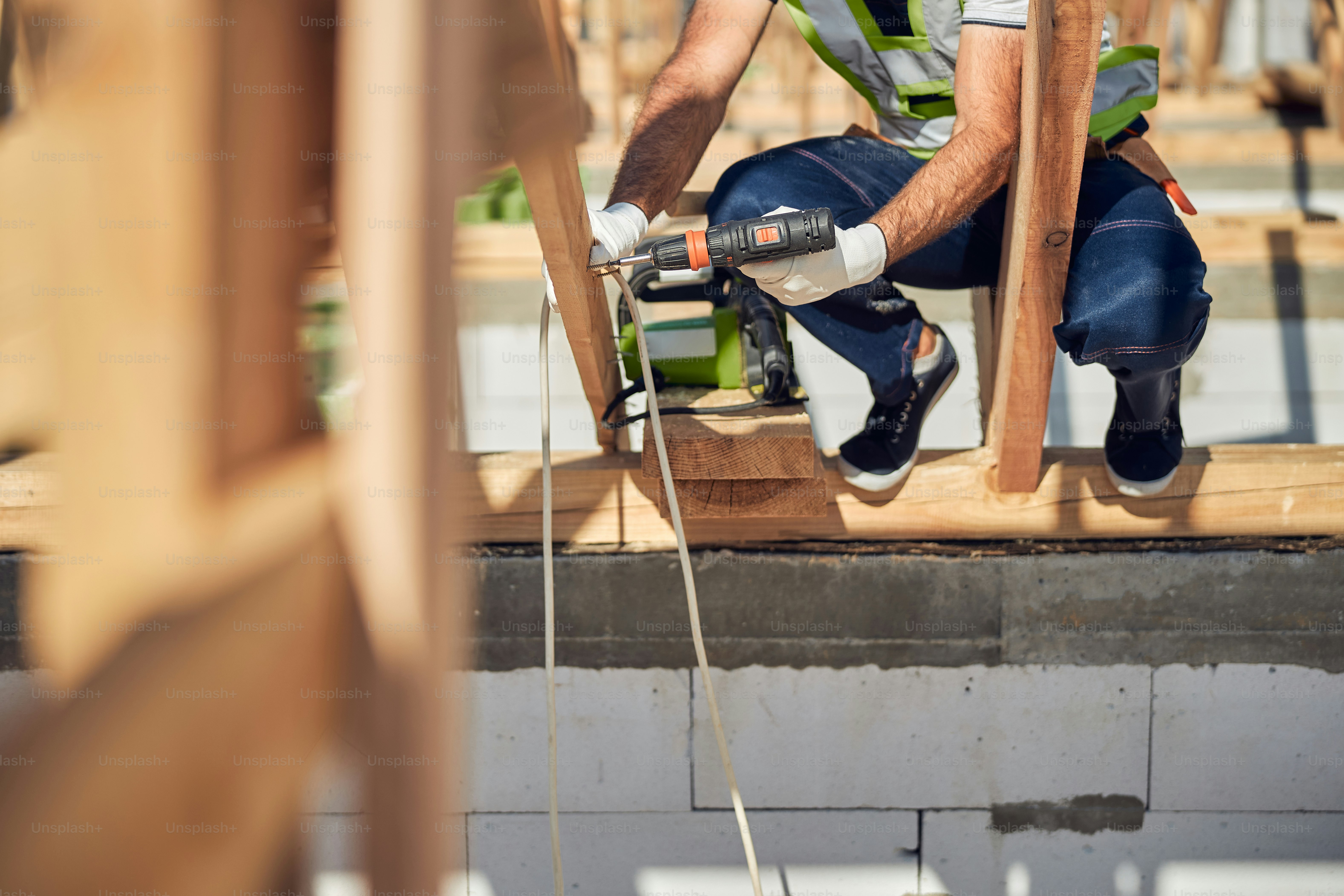 Concentrated foreman standing in semi position while hammering nail ...