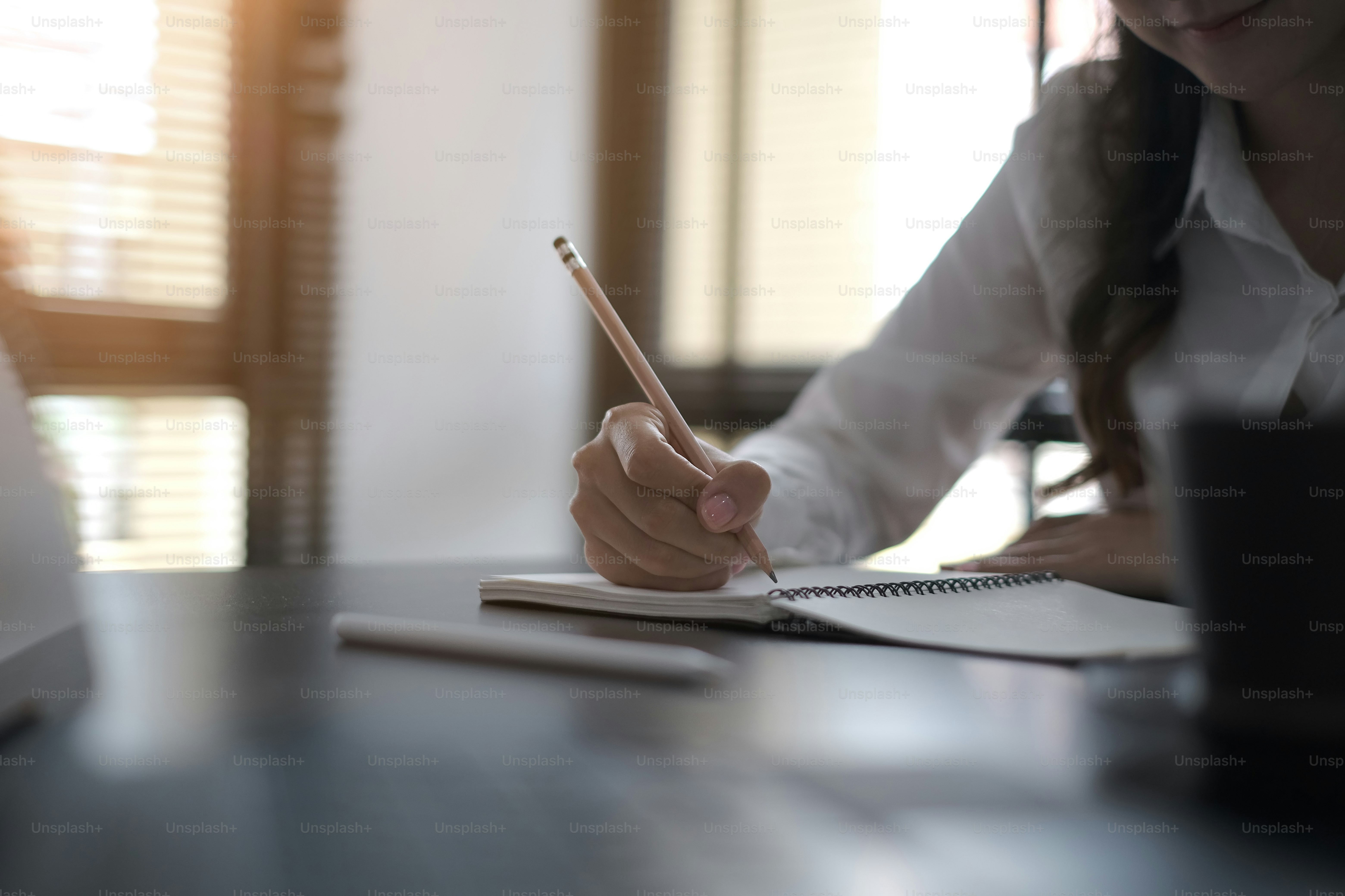 Cropped shot of businesswoman is writing down information on note book ...
