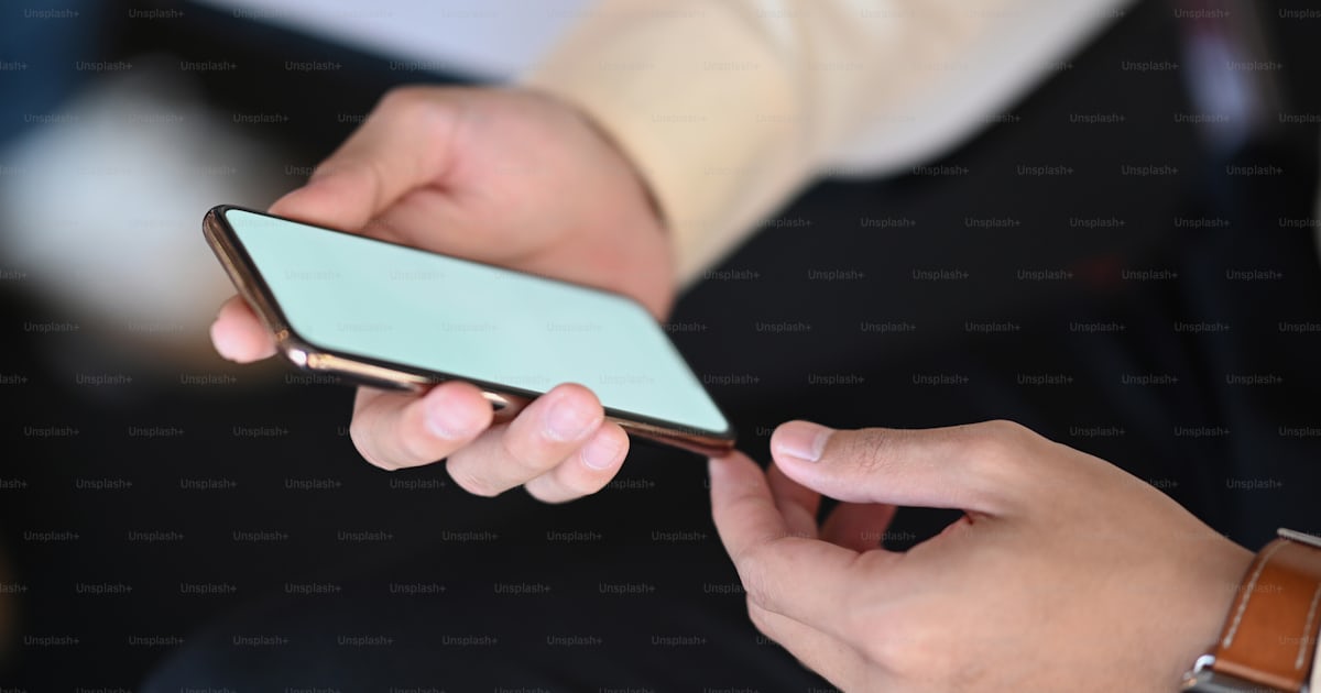 携帯電話を持つ男の手の接写。グラフィック表示モンタージュ用の空白の画面。の写真 タイ Unsplashの写真