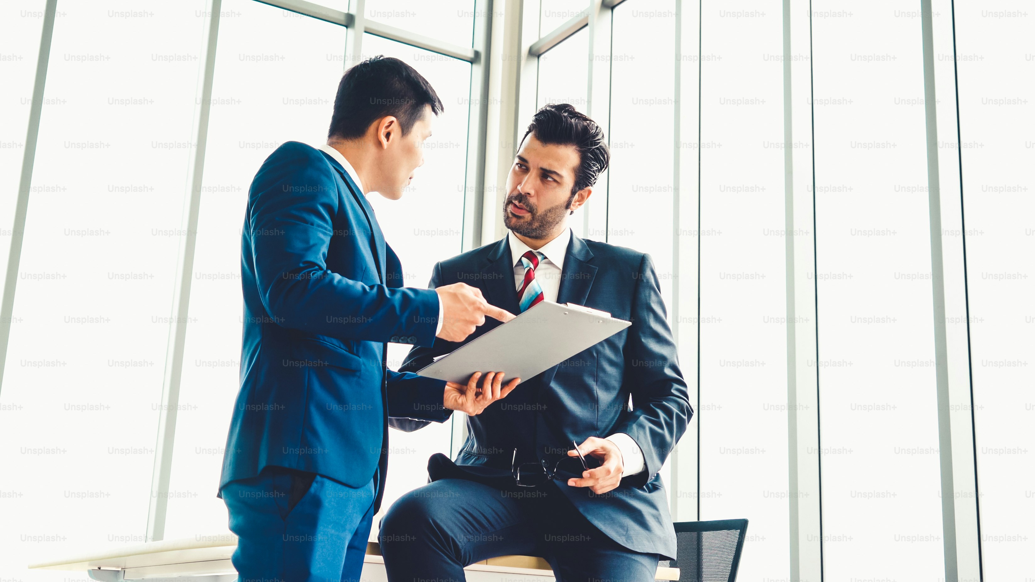 Two business people talk project strategy at office meeting room ...