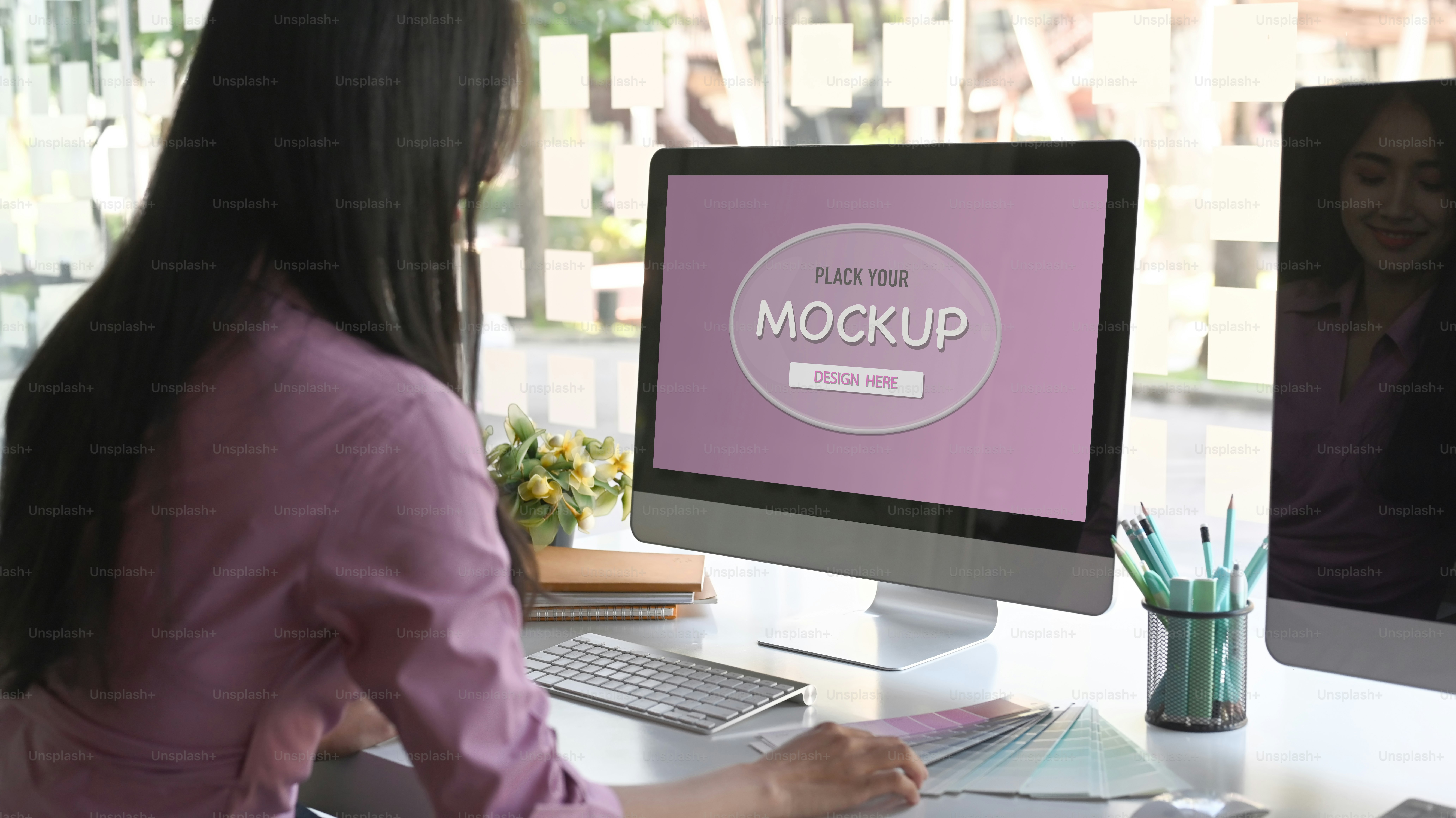 Young woman graphic designer is working on computer. Blank screen ...