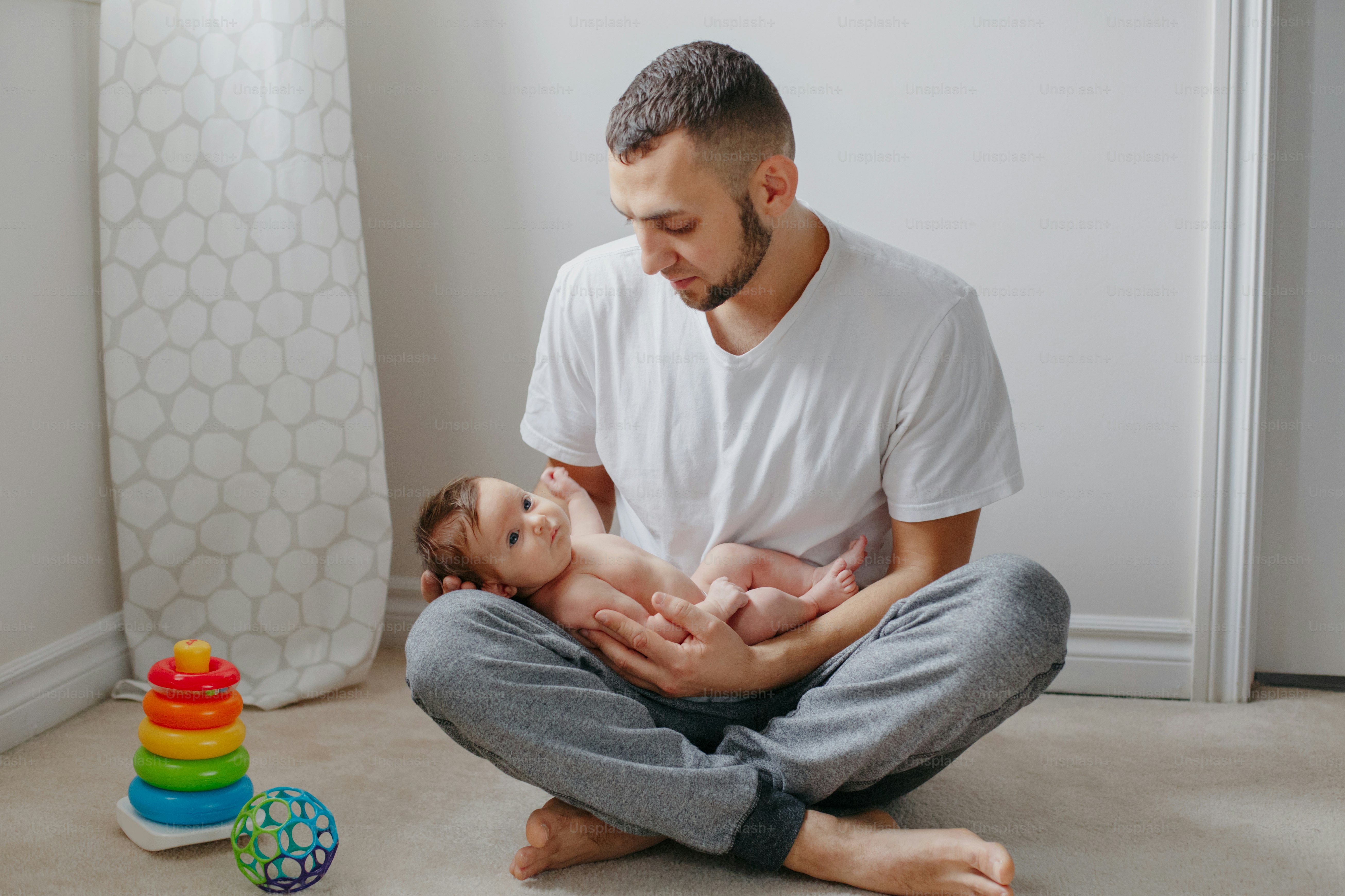 Happy Caucasian father holding newborn baby on laps knees. Man parent ...