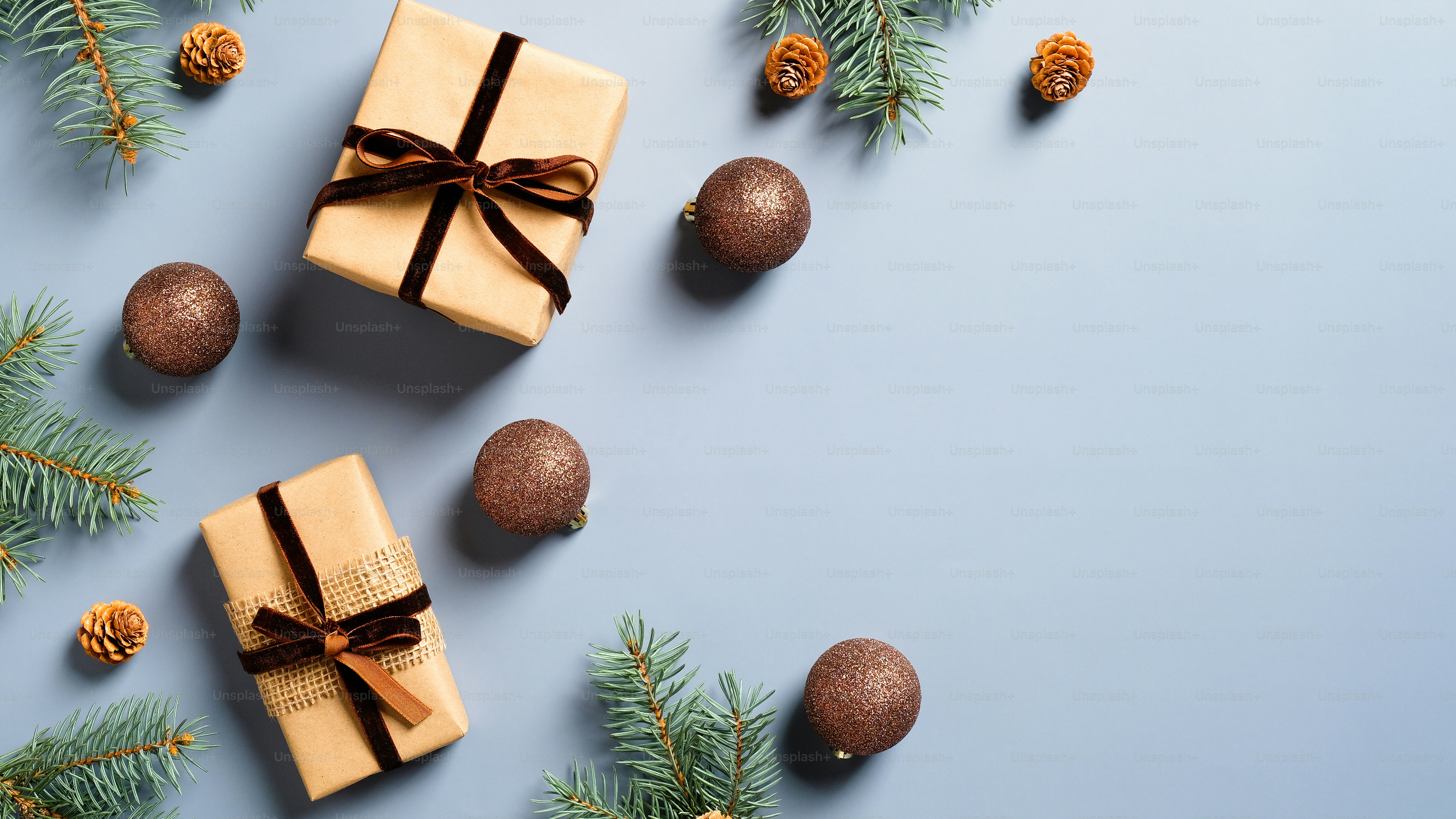 Christmas gift boxes and brown baubles with pine branches on pastel ...