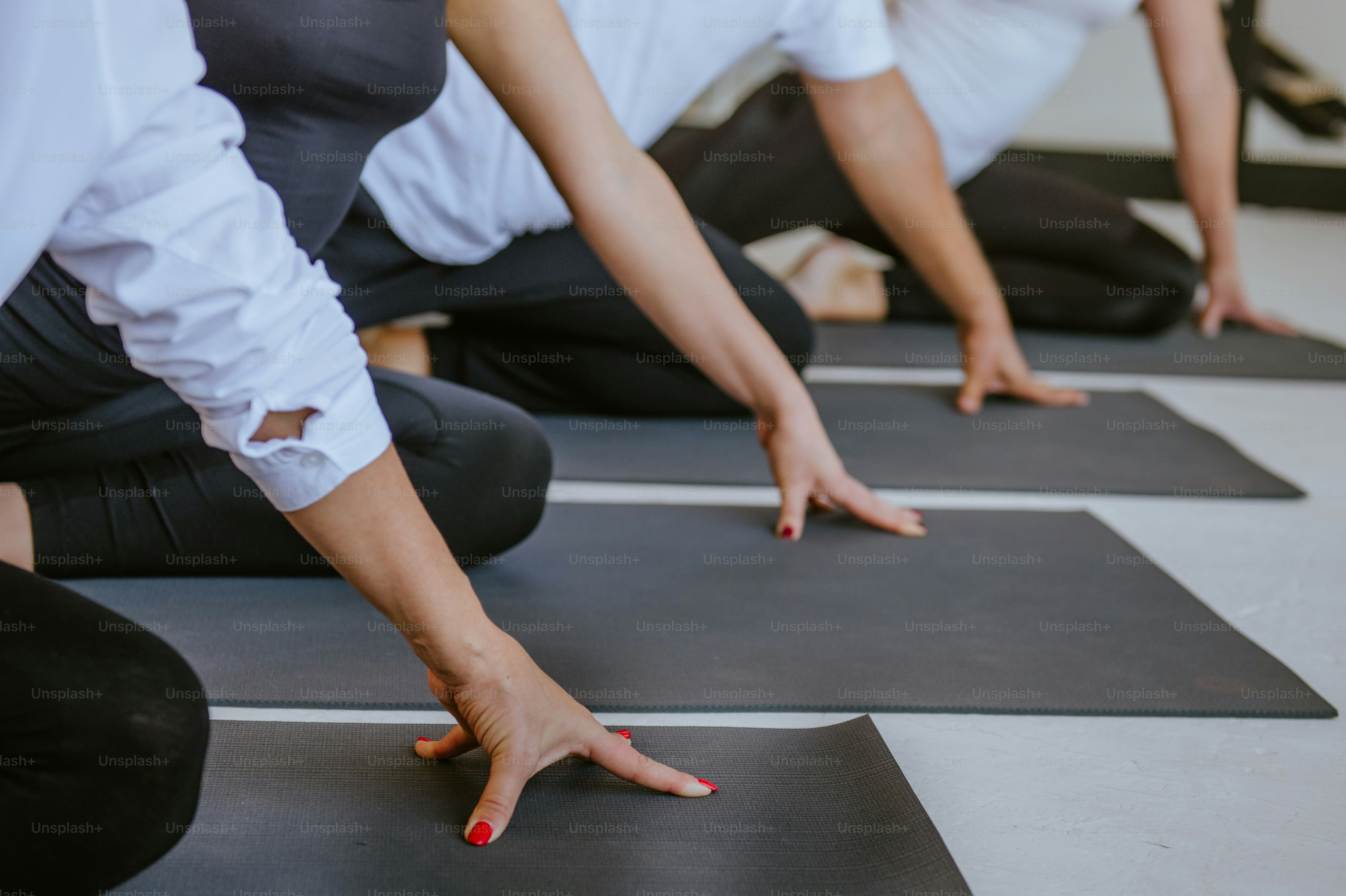 Close up of young people practicing yoga. Yoga group class for adults ...