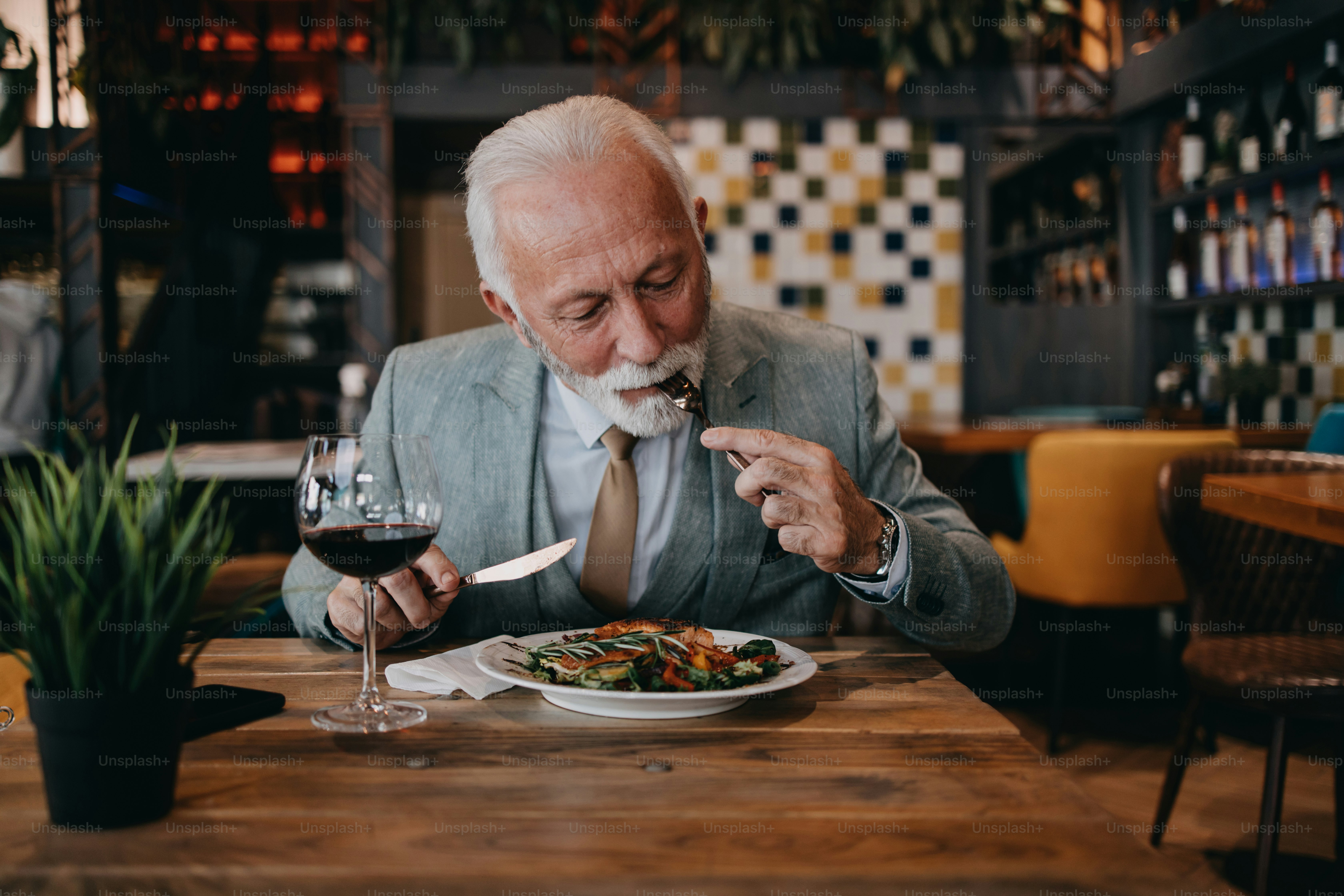 Happy businessman sitting in restaurant and having lunch. He is ...
