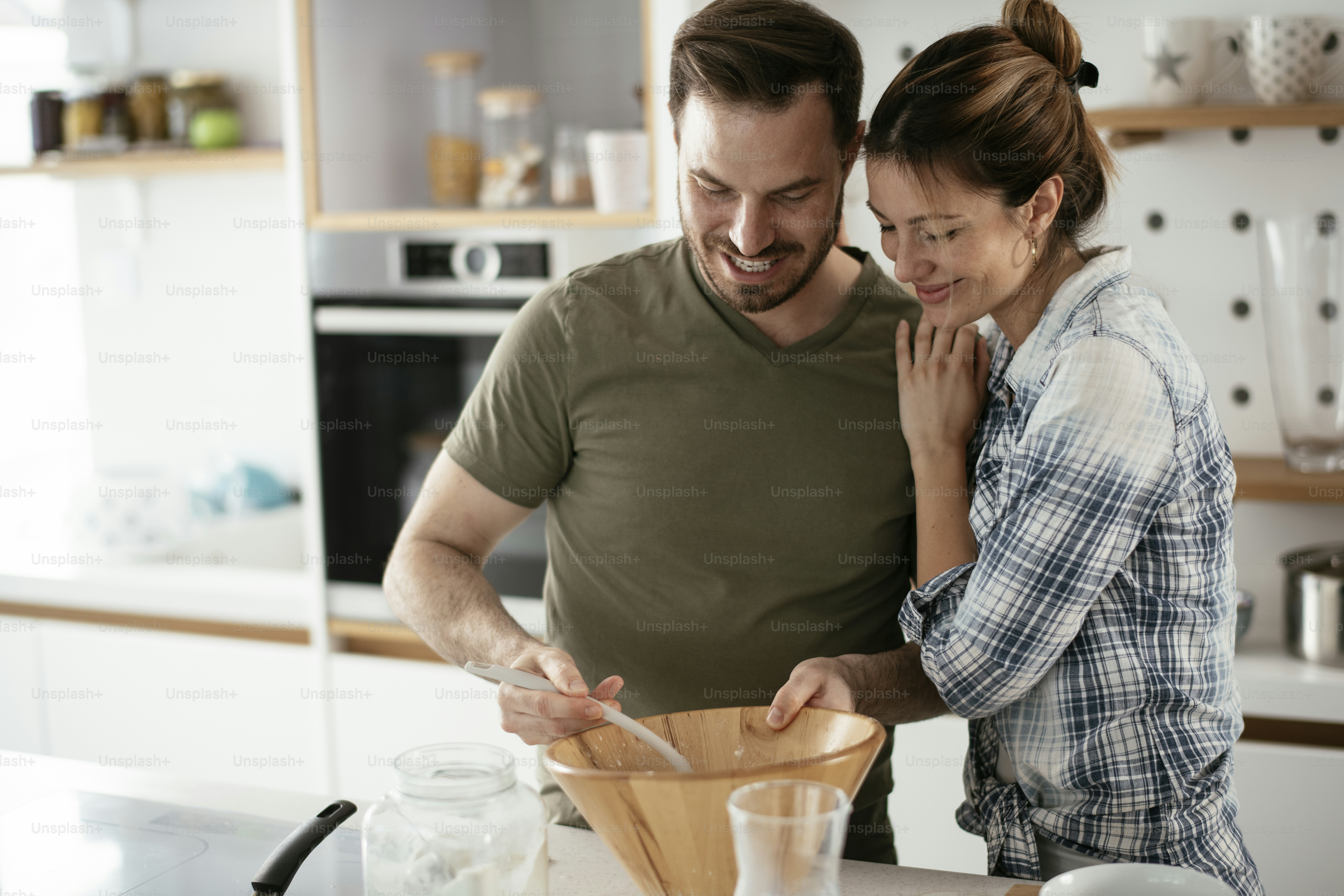 Husband and wife making pancakes at home. Loving couple having fun ...