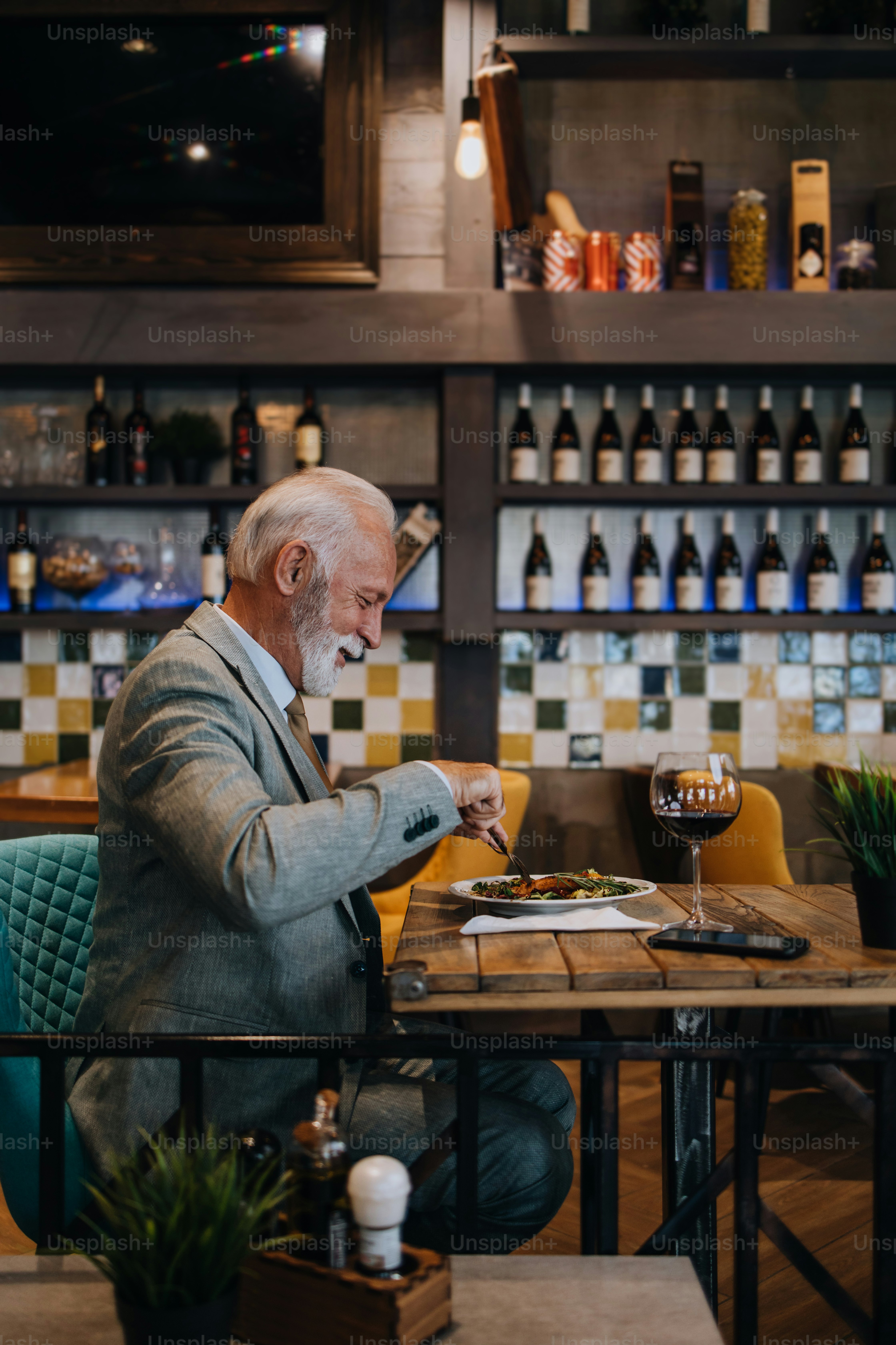 Happy businessman sitting in restaurant and having lunch. He is ...