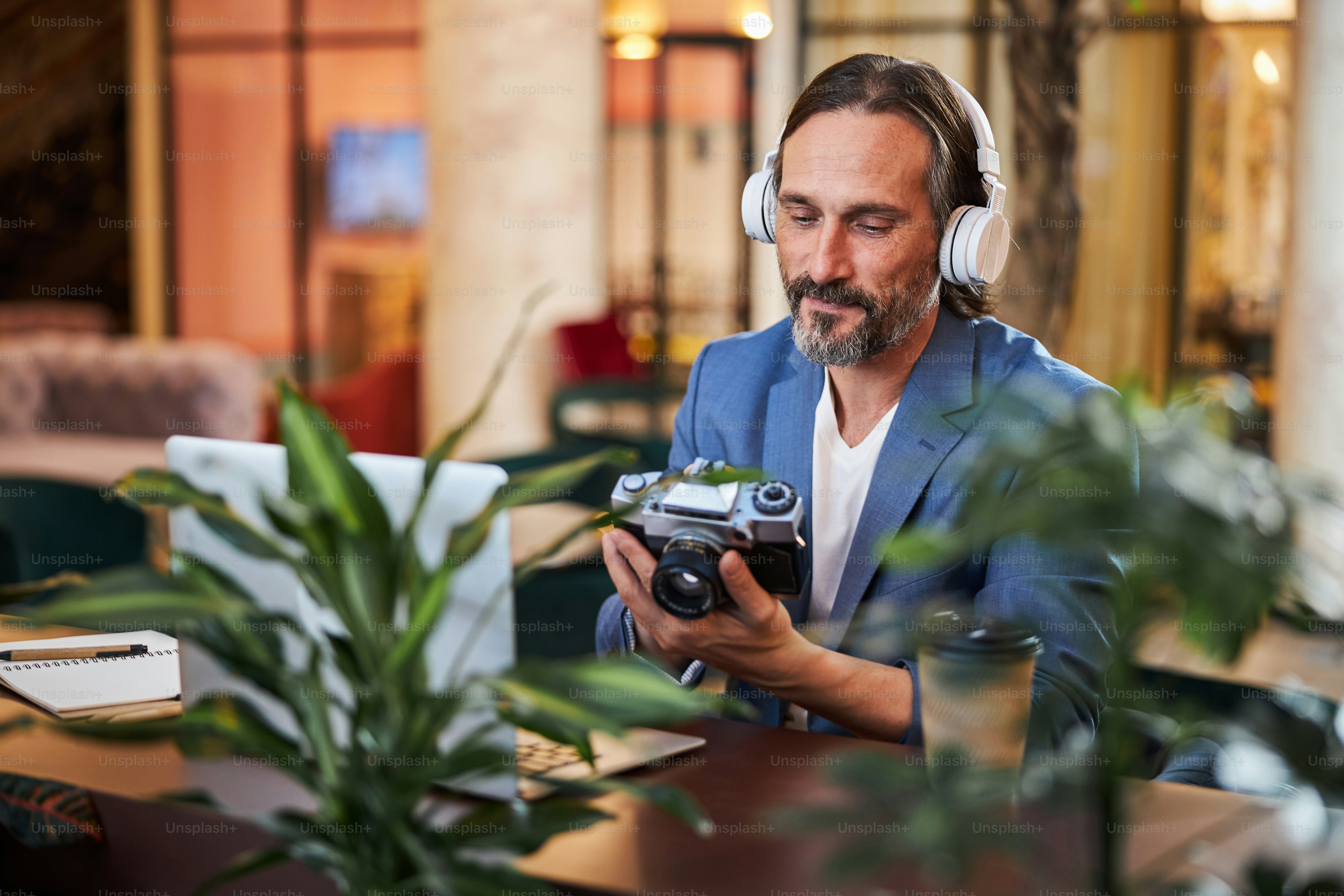 Mature gentleman in headphones looking appreciative of stylish vintage ...