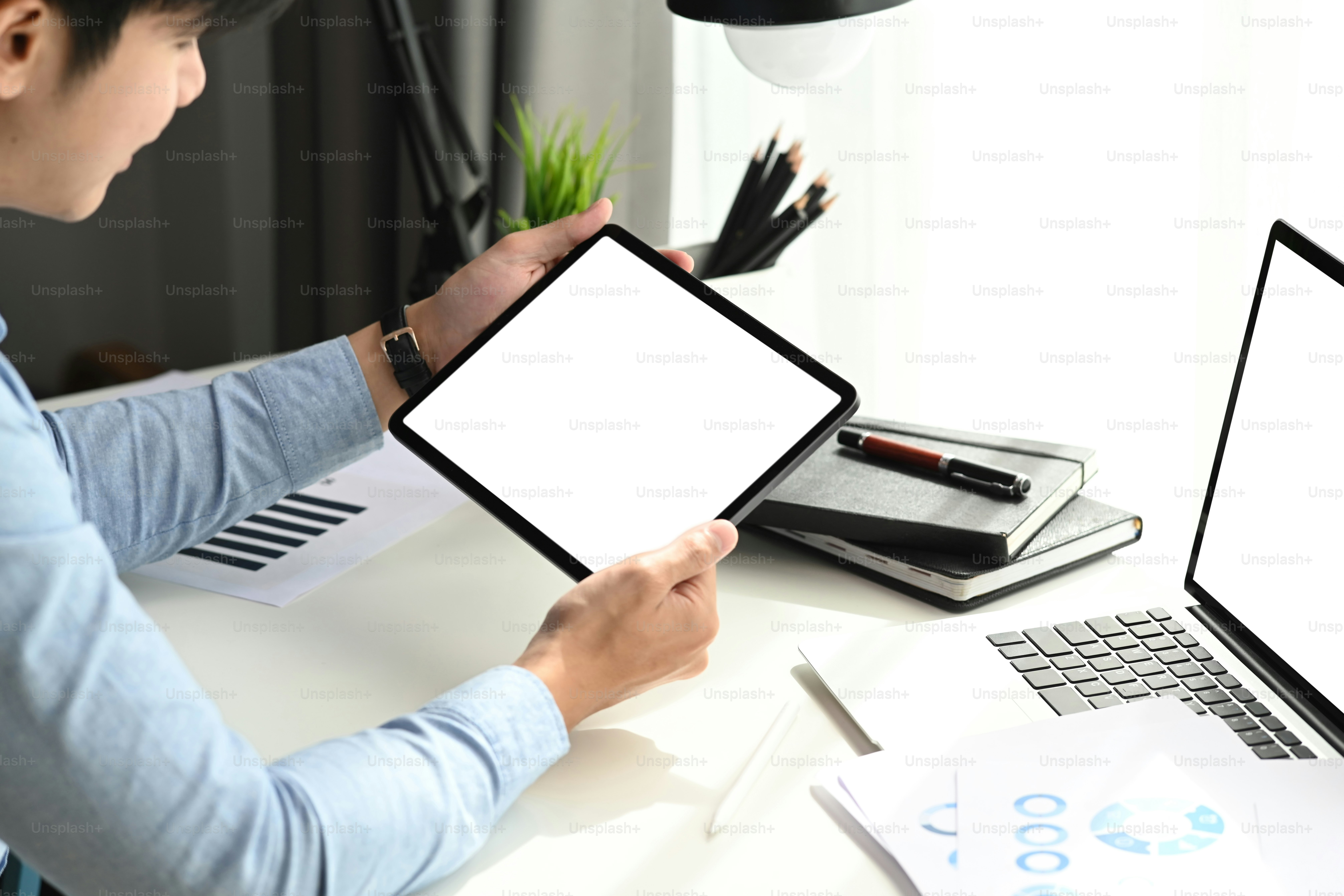 Cropped shot of young man holding tablet and searching information at ...