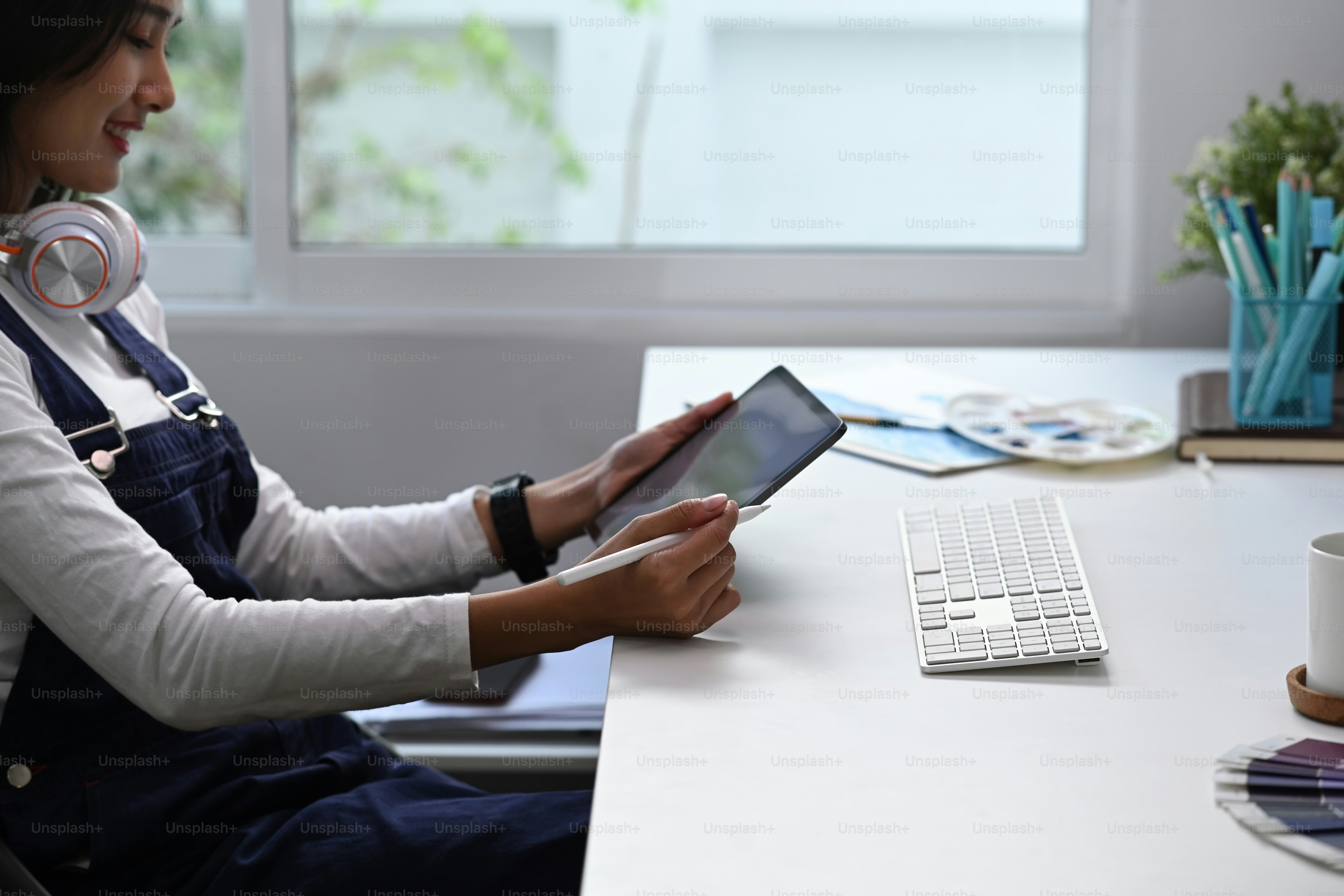A young Graphic Designer Working on a digital tablet and sitting at her ...
