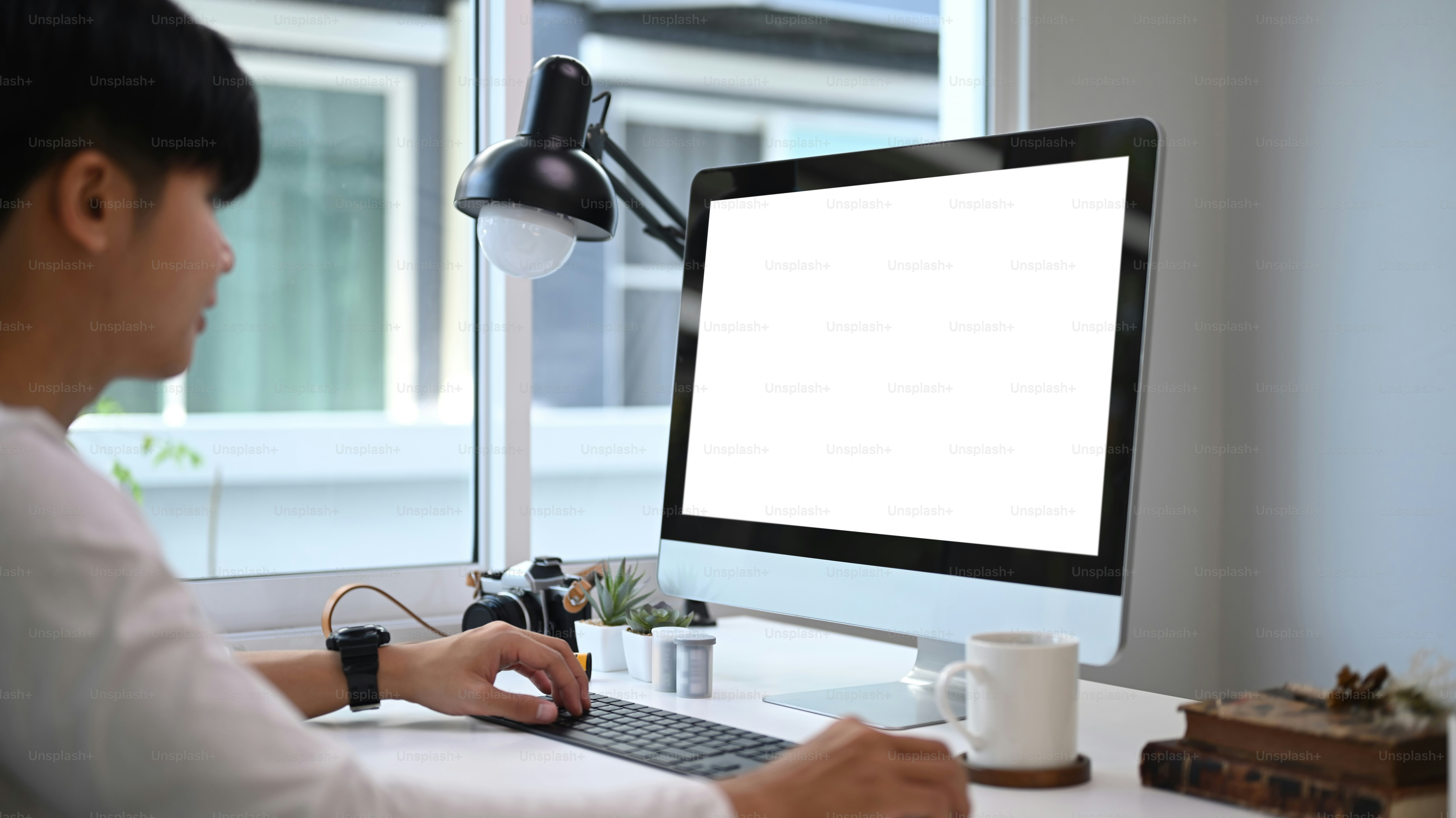 A young graphic designer sitting in front of computer at graphic studio ...