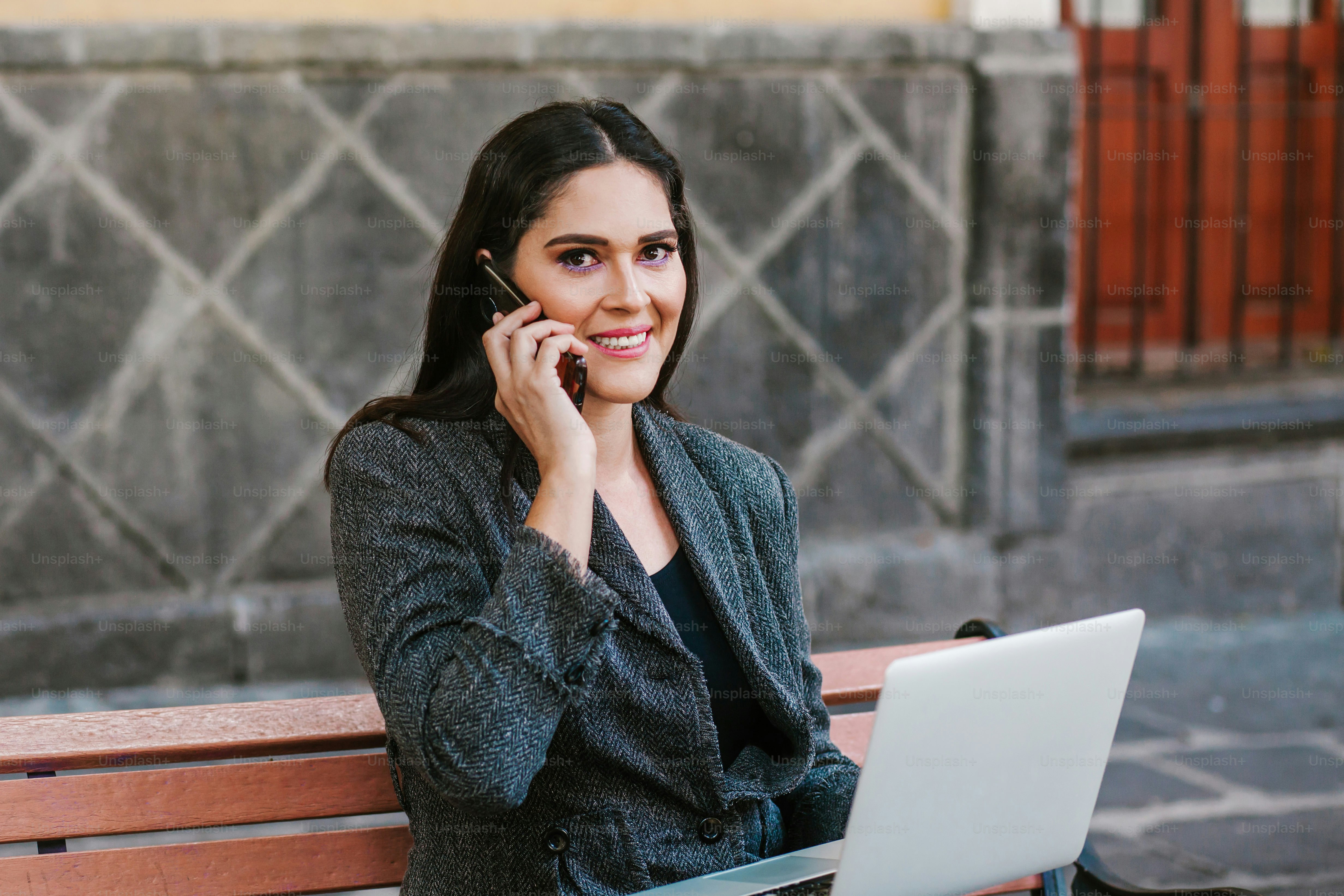 Latin woman working with her laptop and coffee in a colonial city in ...