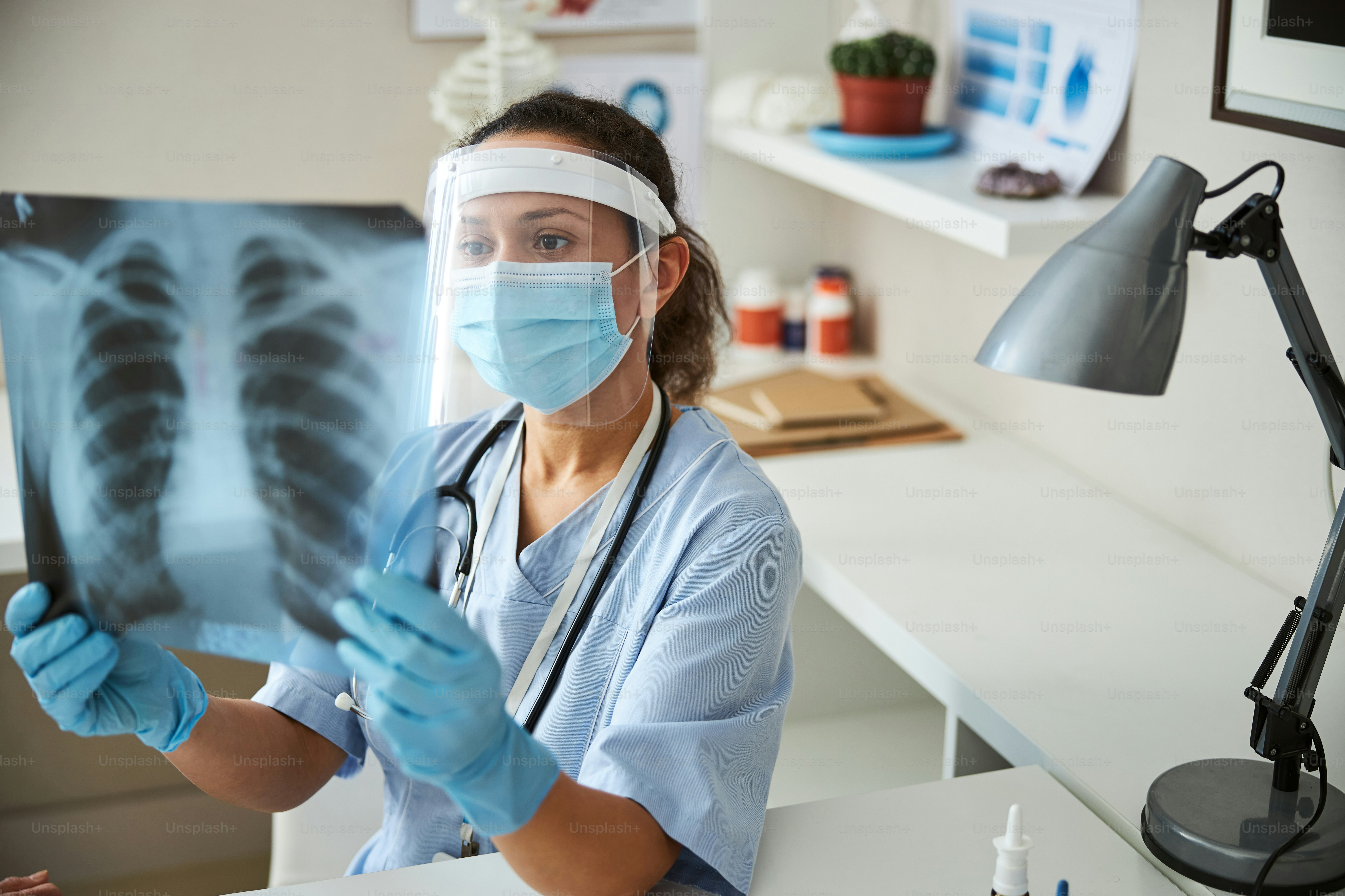 Female general practitioner inspecting a radiograph of her patient ...