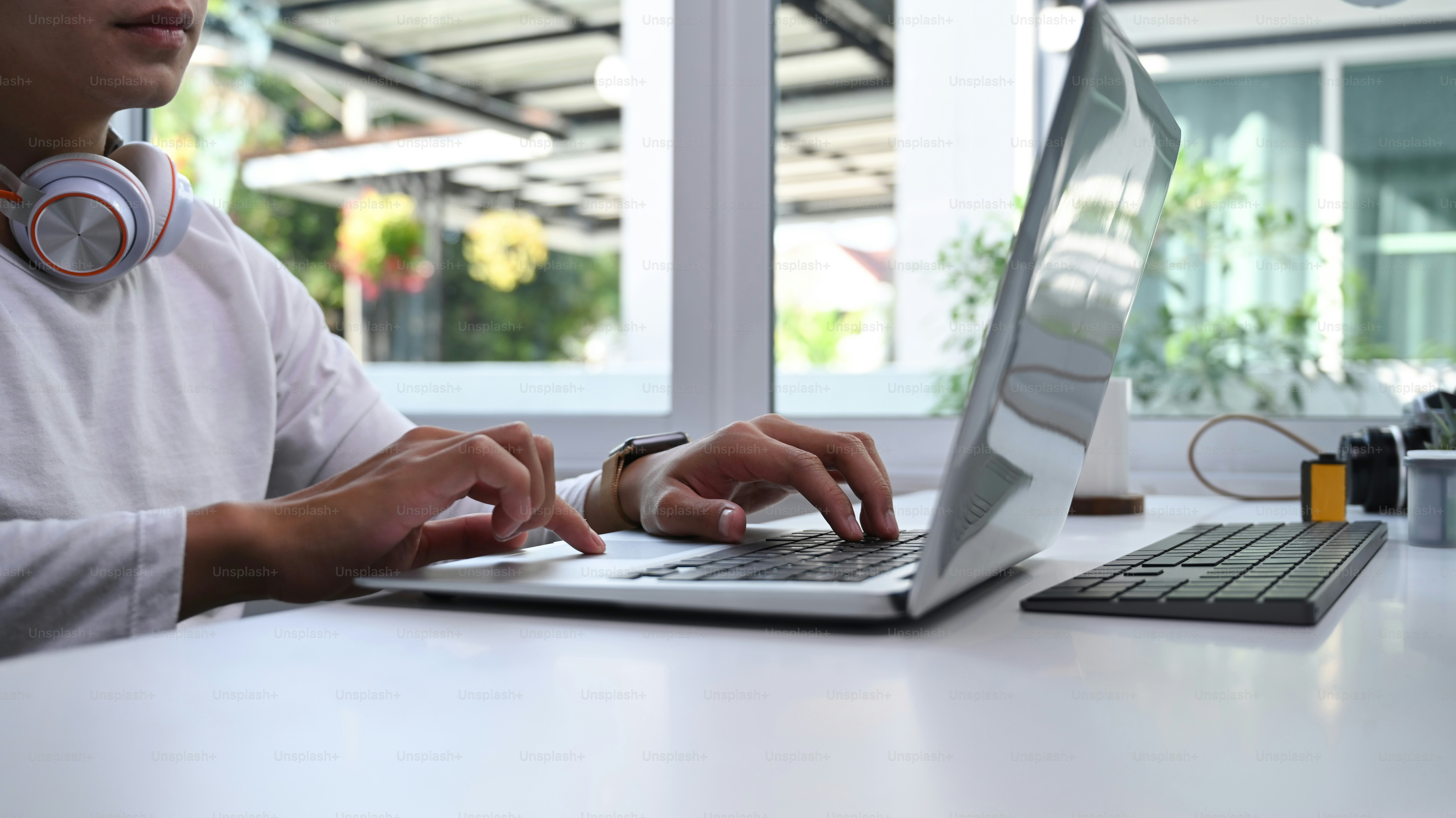 Close up view of photographer hands typing on laptop computer at his ...