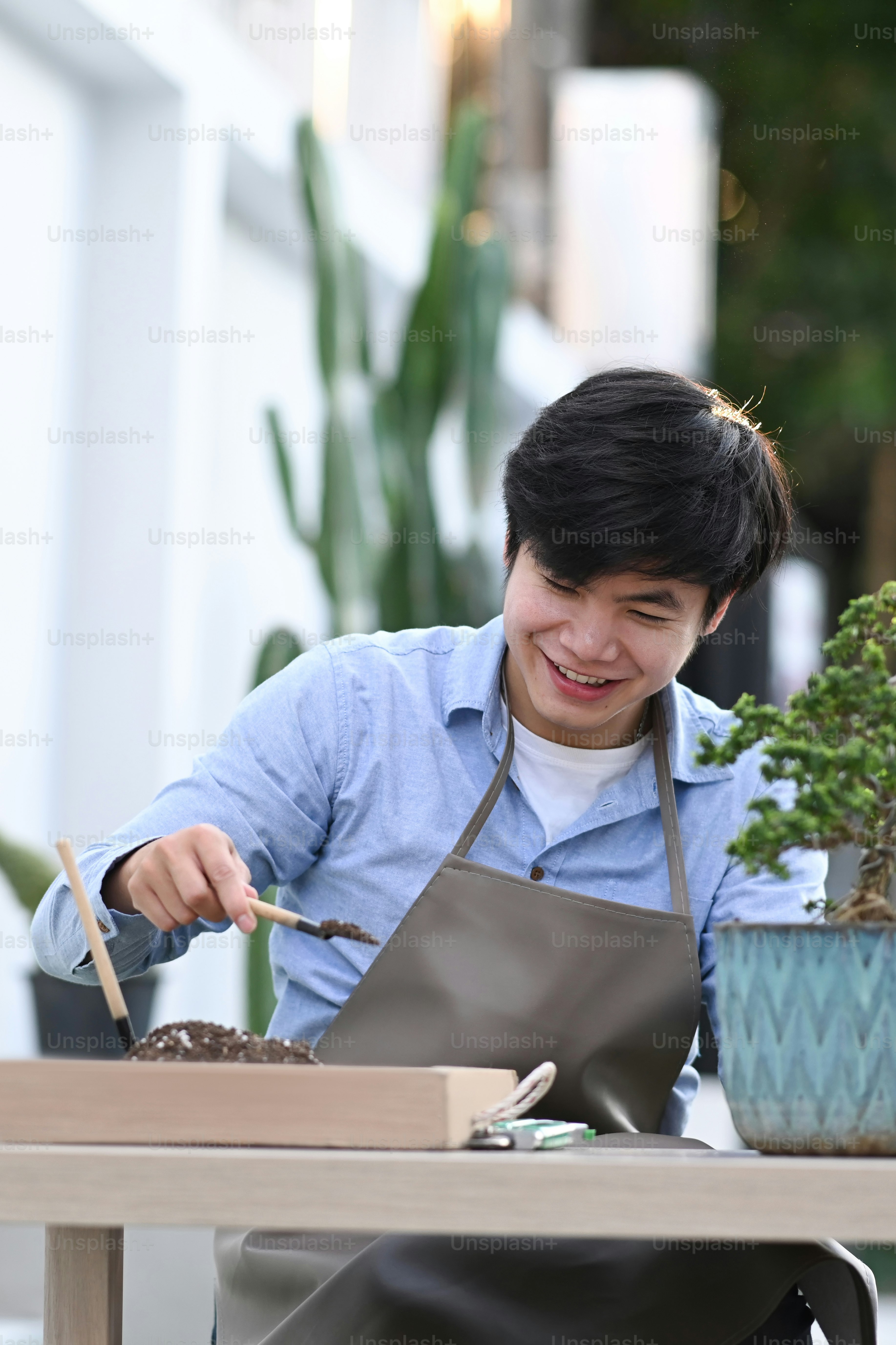 Foto Retrato de jardinero feliz plantando flores a mano en maceta con ...