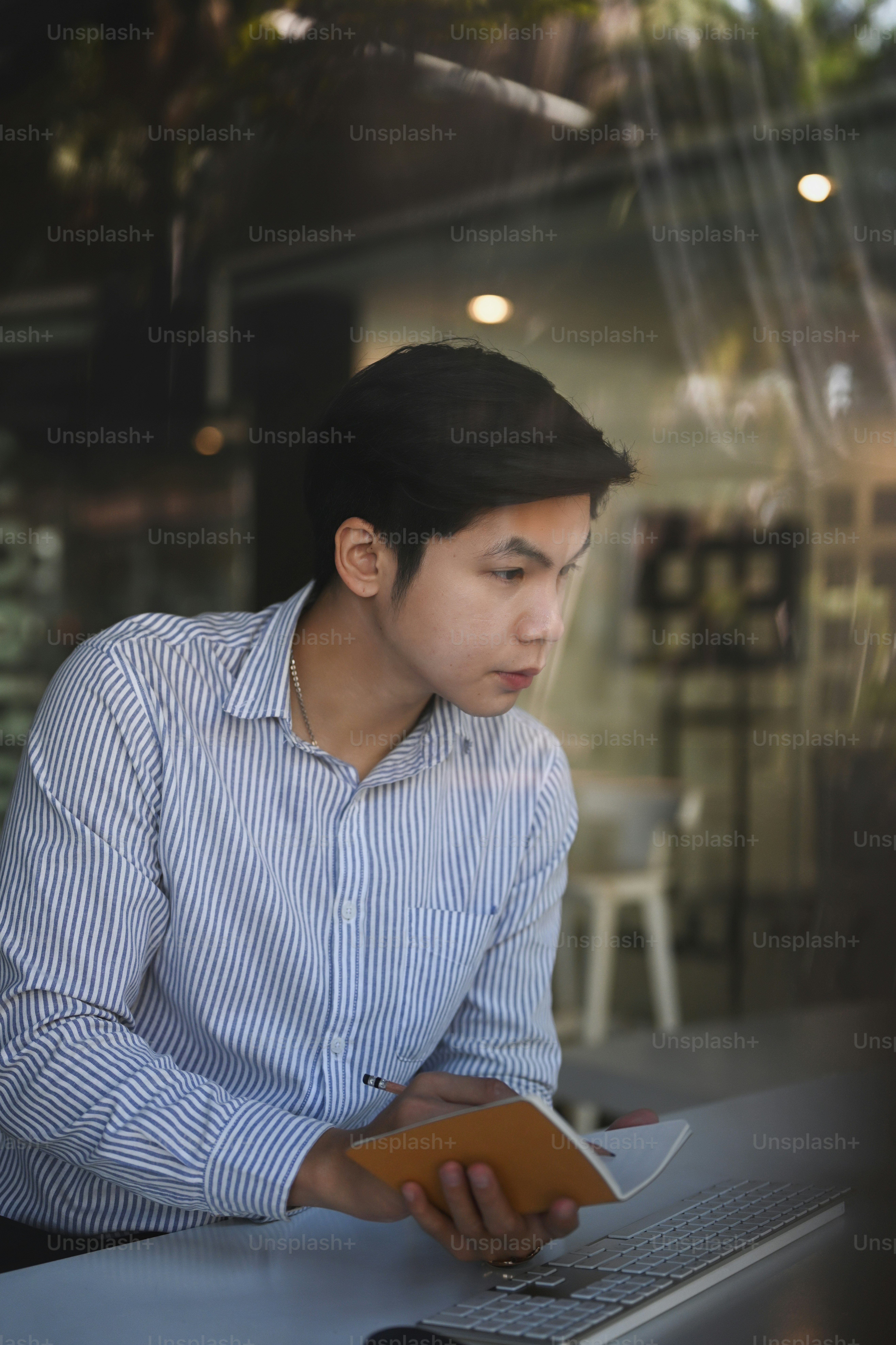 Portrait of young man employee working with laptop computer in modern ...