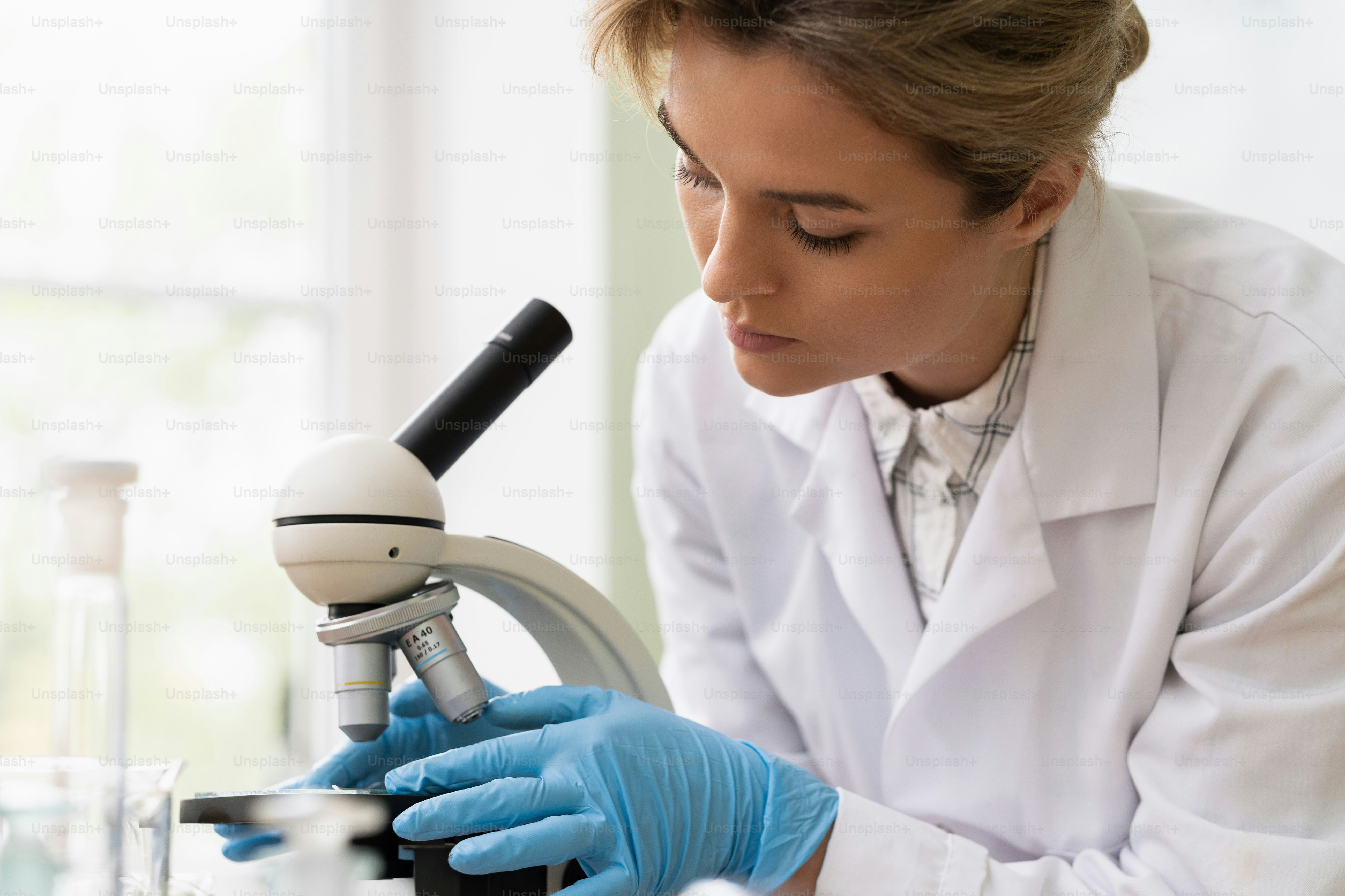 Woman scientist is using microscope in a laboratory during research ...