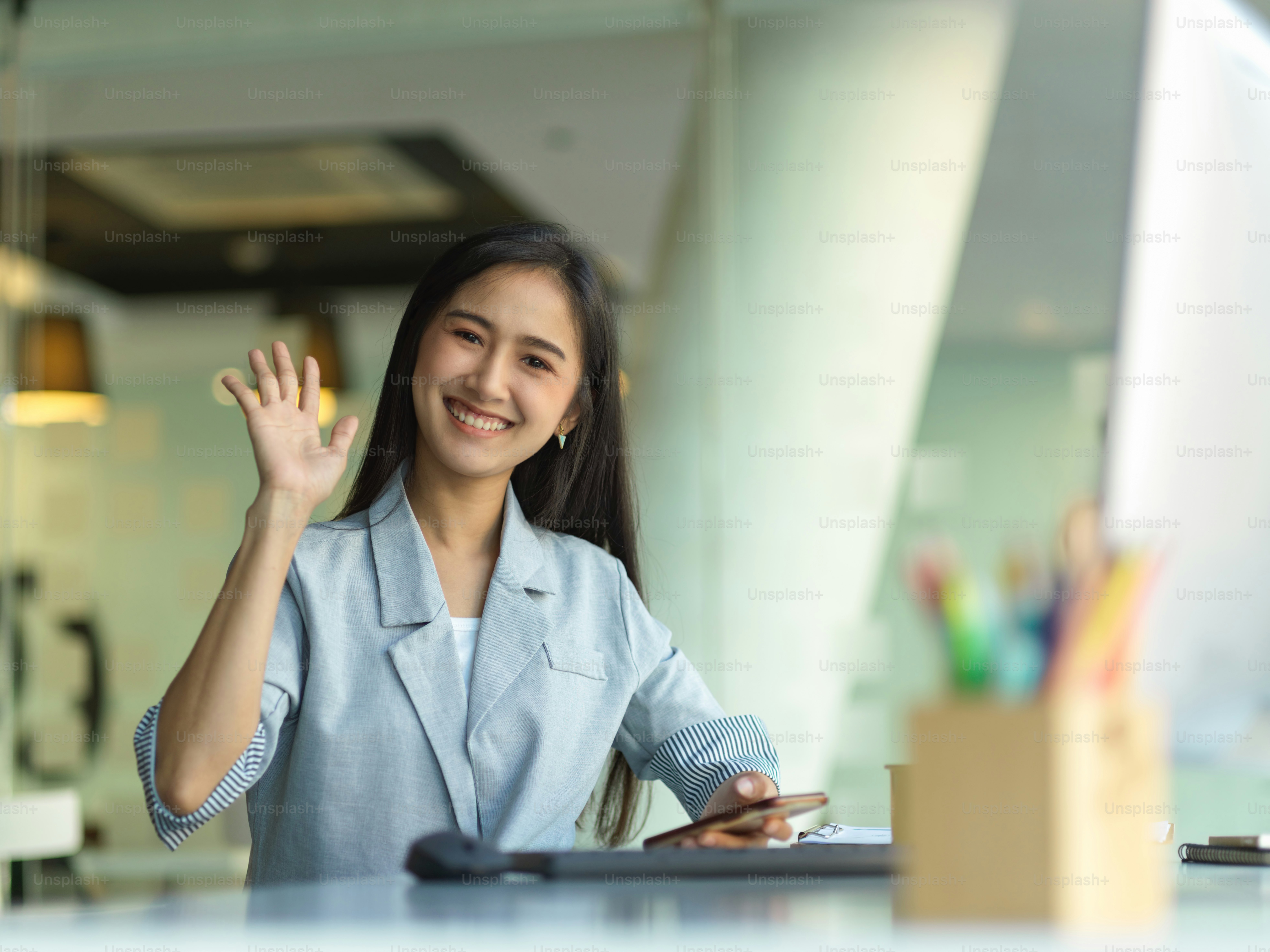 Portrait of businesswoman showing five fingers, waving hand to say ...