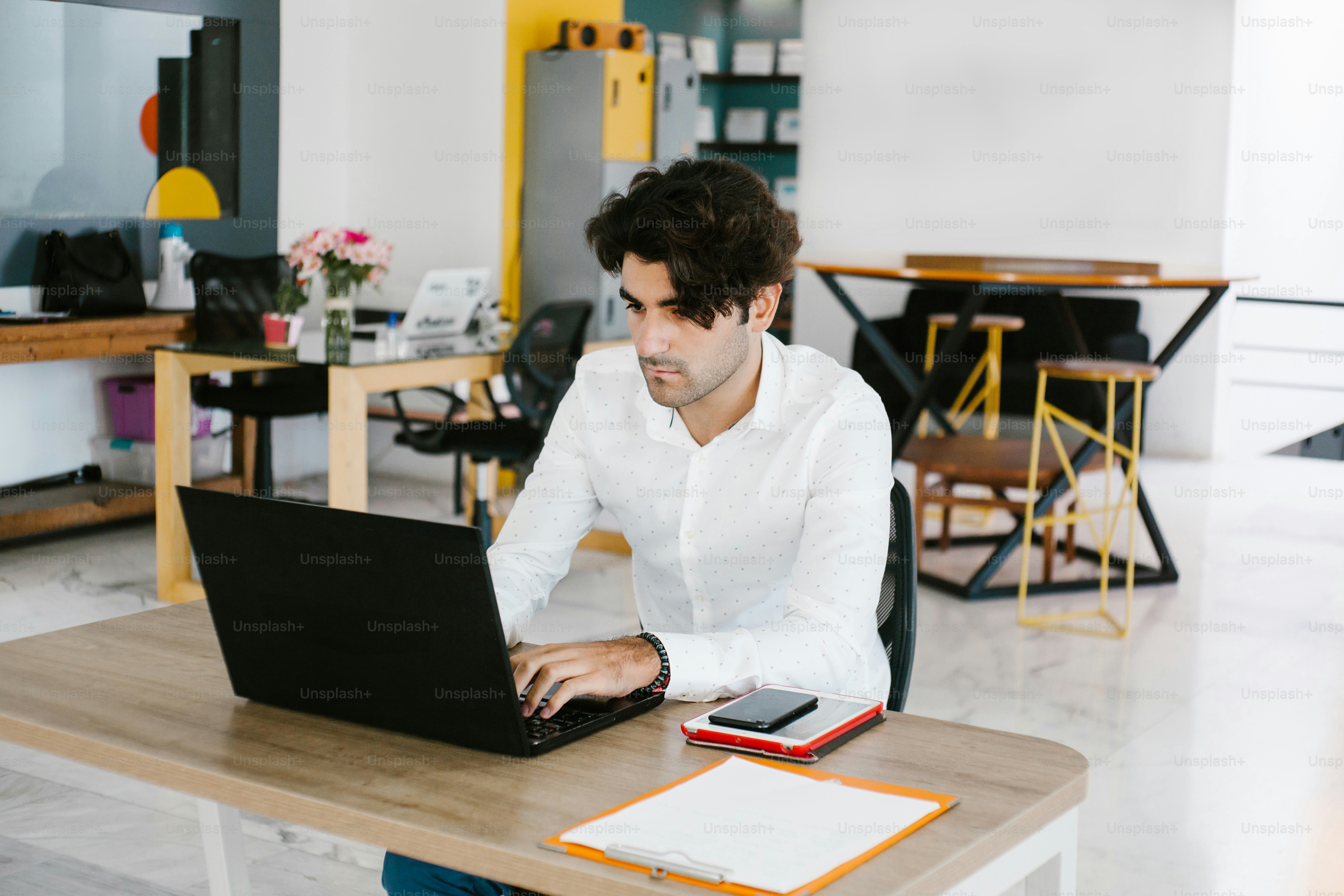 Young latin american man working at computer at office in Mexico city ...