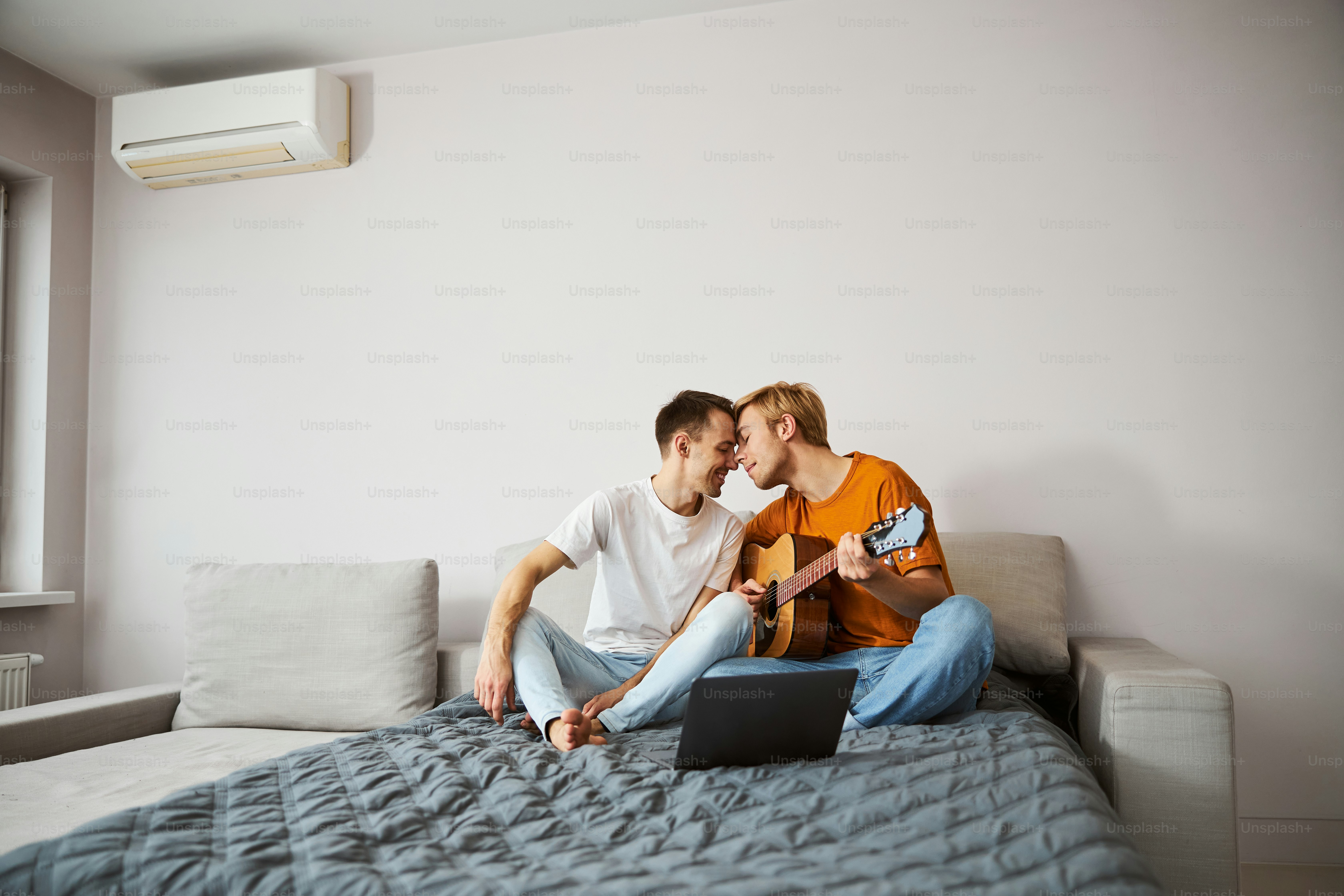 Handsome young man playing guitar and sharing tender moment with ...