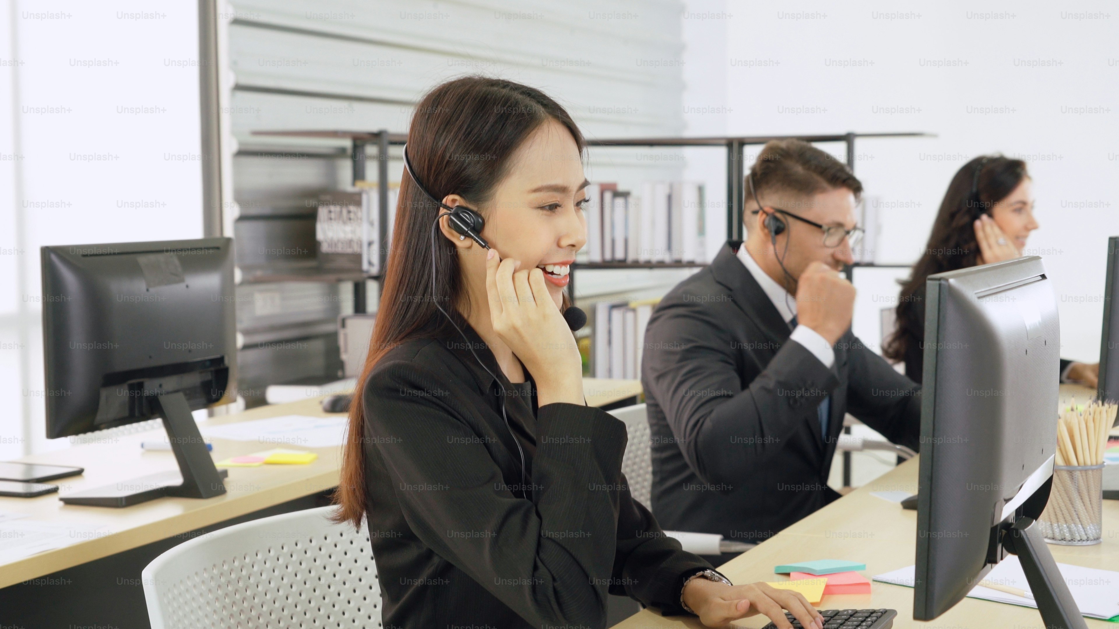 Business people wearing headset working in office to support remote ...