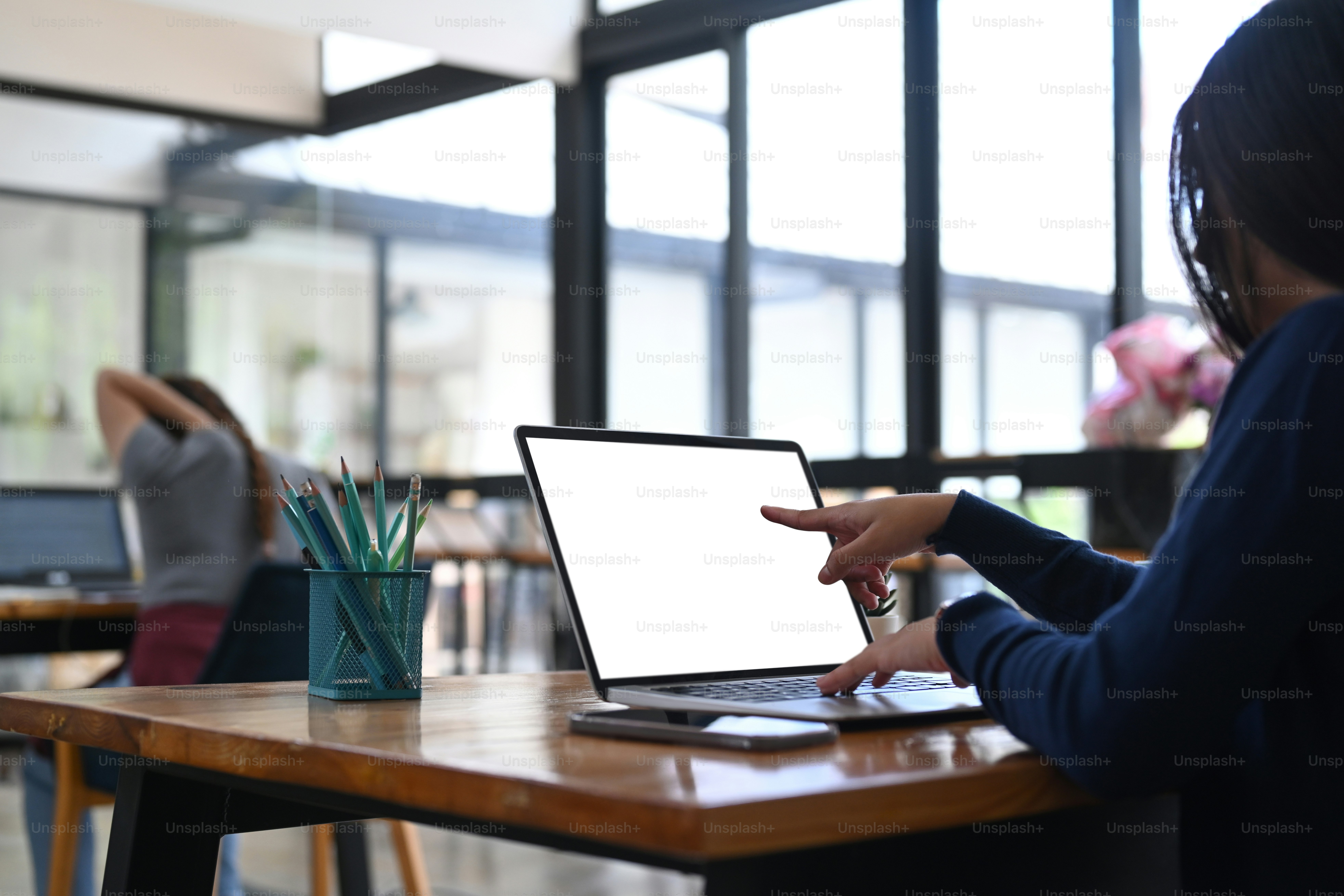 Side view of young woman freelance pointing on screen of laptop ...