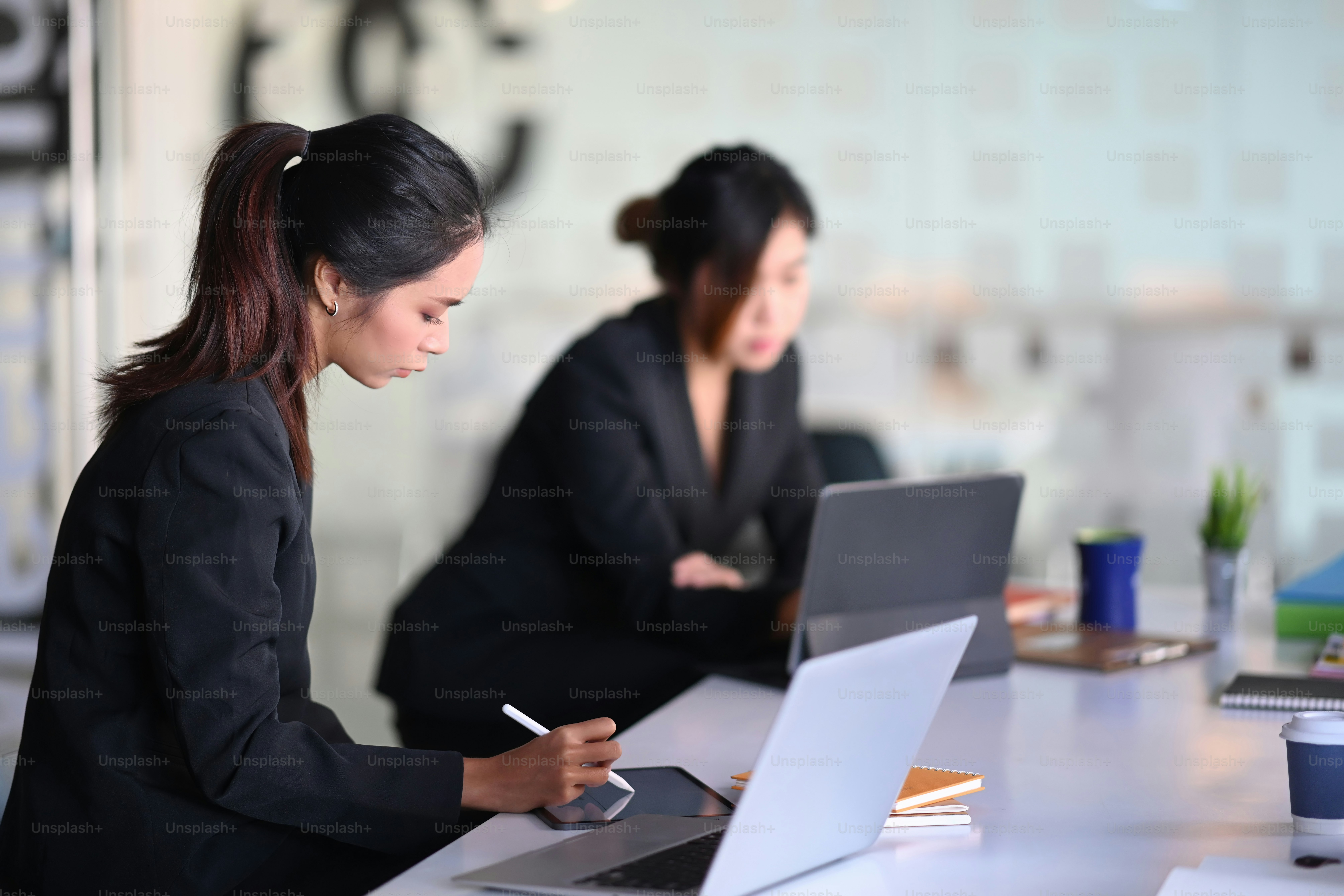 Two businesswoman working and planning a strategy in modern office ...