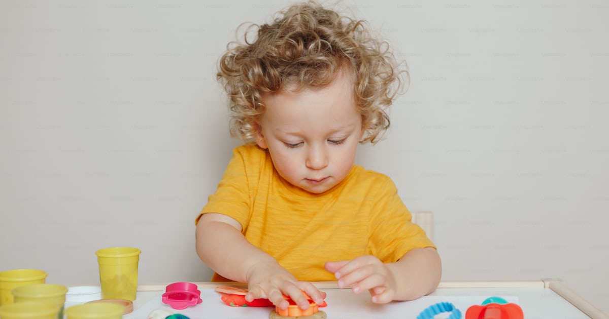 Simpatico bambino riccio biondo caucasico che gioca con la plastilina ... Simpatico bambino riccio biondo caucasico che gioca con la plastilina ...