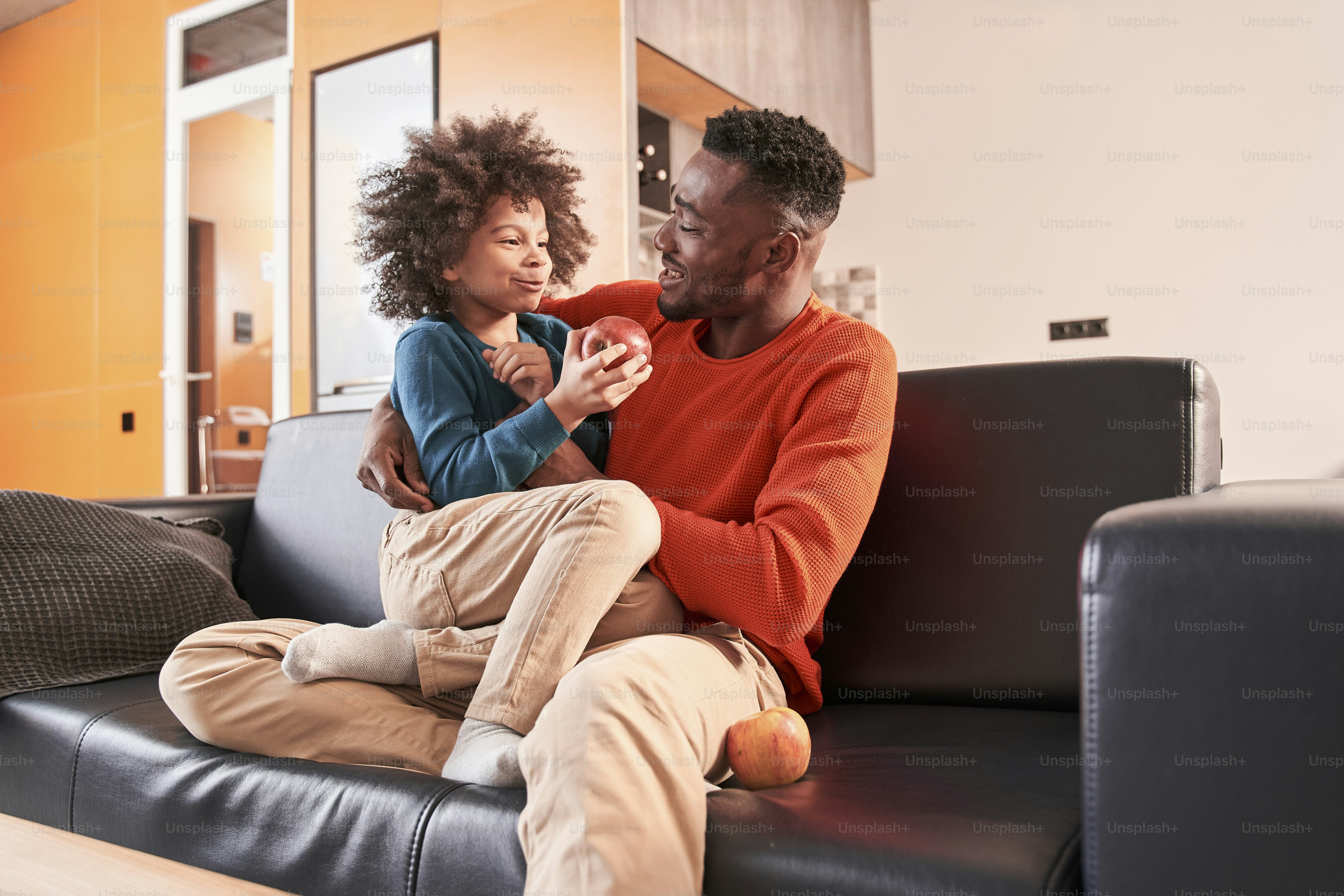 Best friends. Curly multiracial boy sitting with his friendly father ...