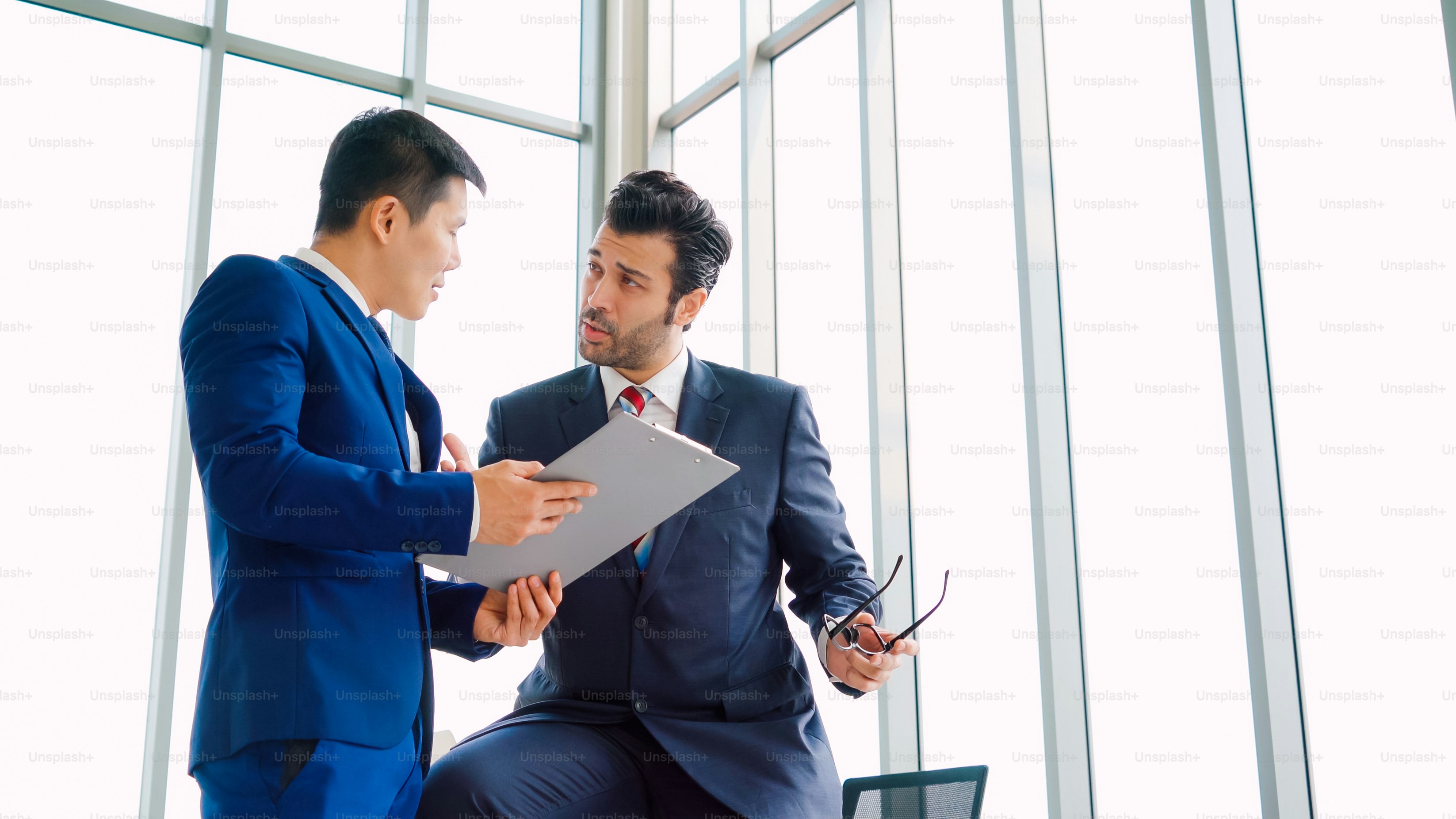Two business people talk project strategy at office meeting room ...