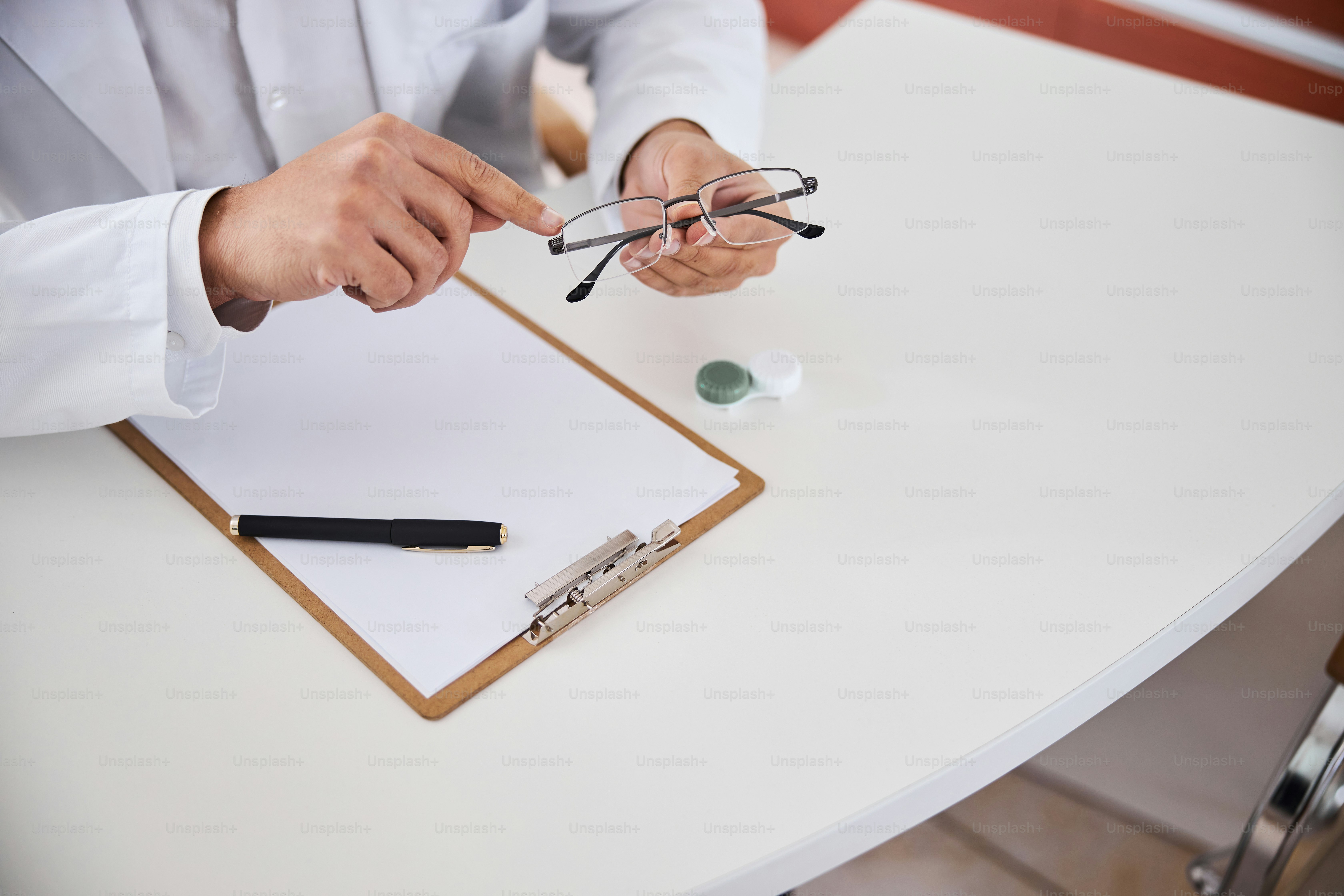 Cropped photo of a male optometrist demonstrating semi-rimless ...